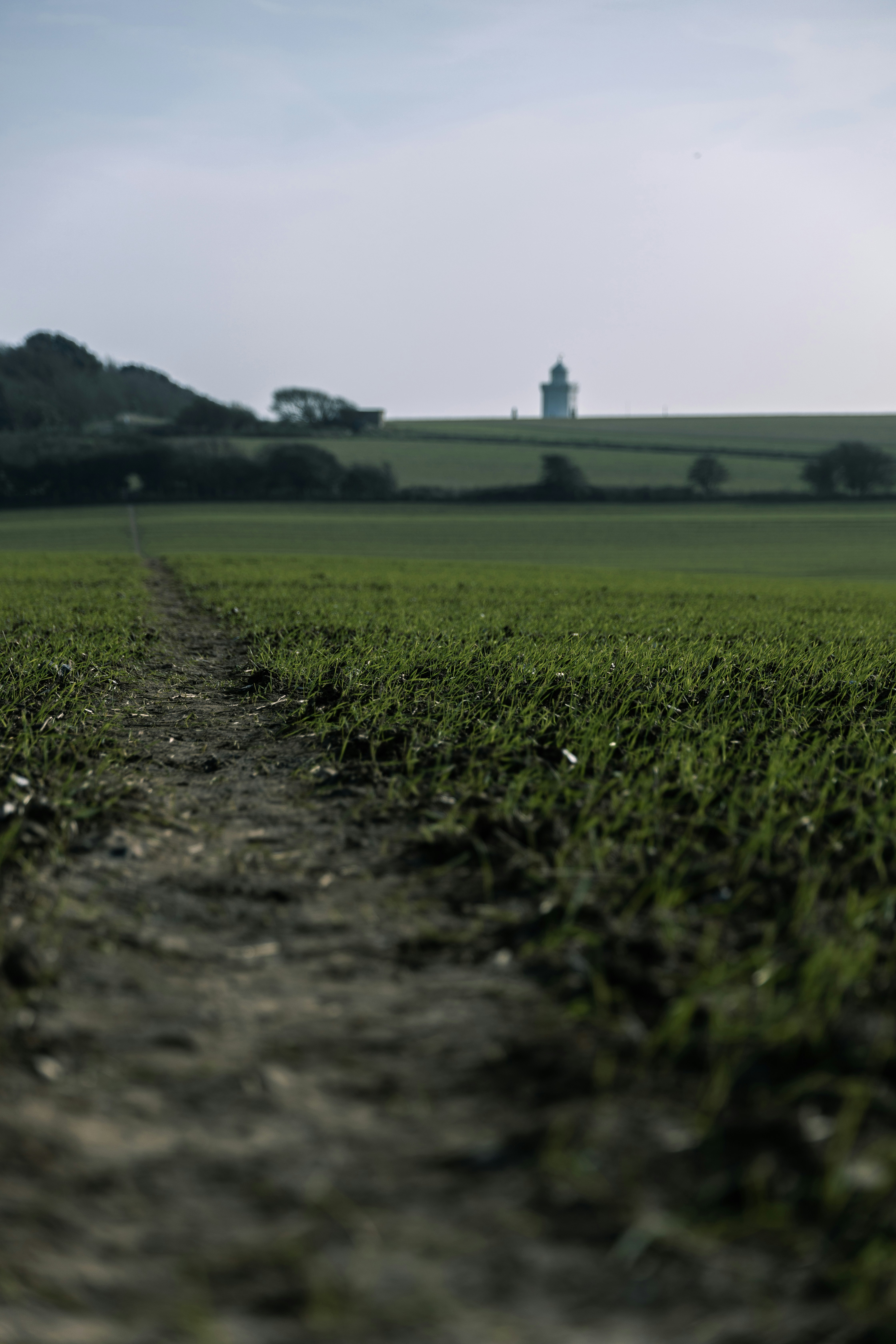 low-angle photography of grass field with building on top of mountain during daytime