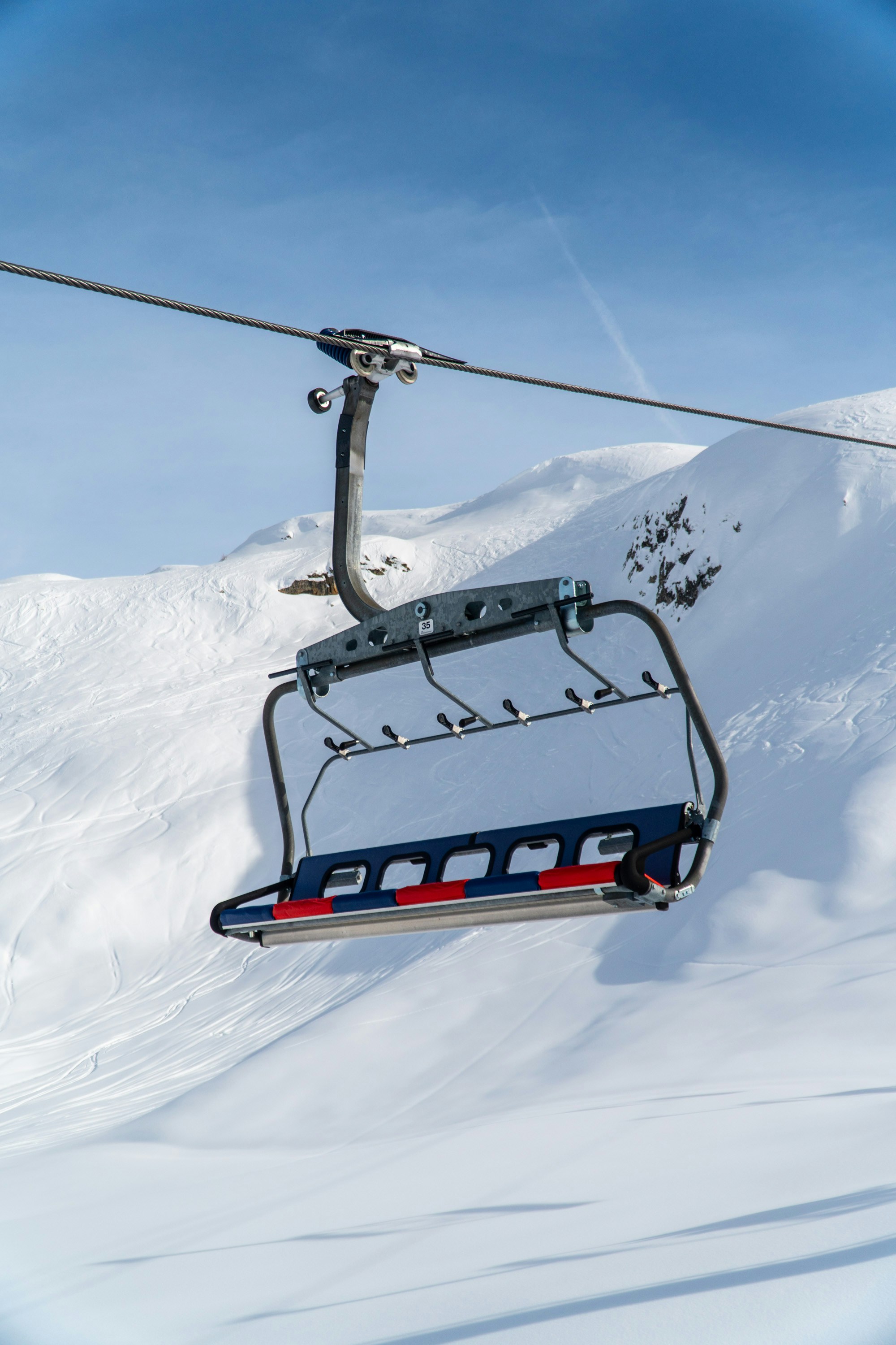 Suspended Over Pristine Powder: Alpine Chairlift in Snowbound Silence
