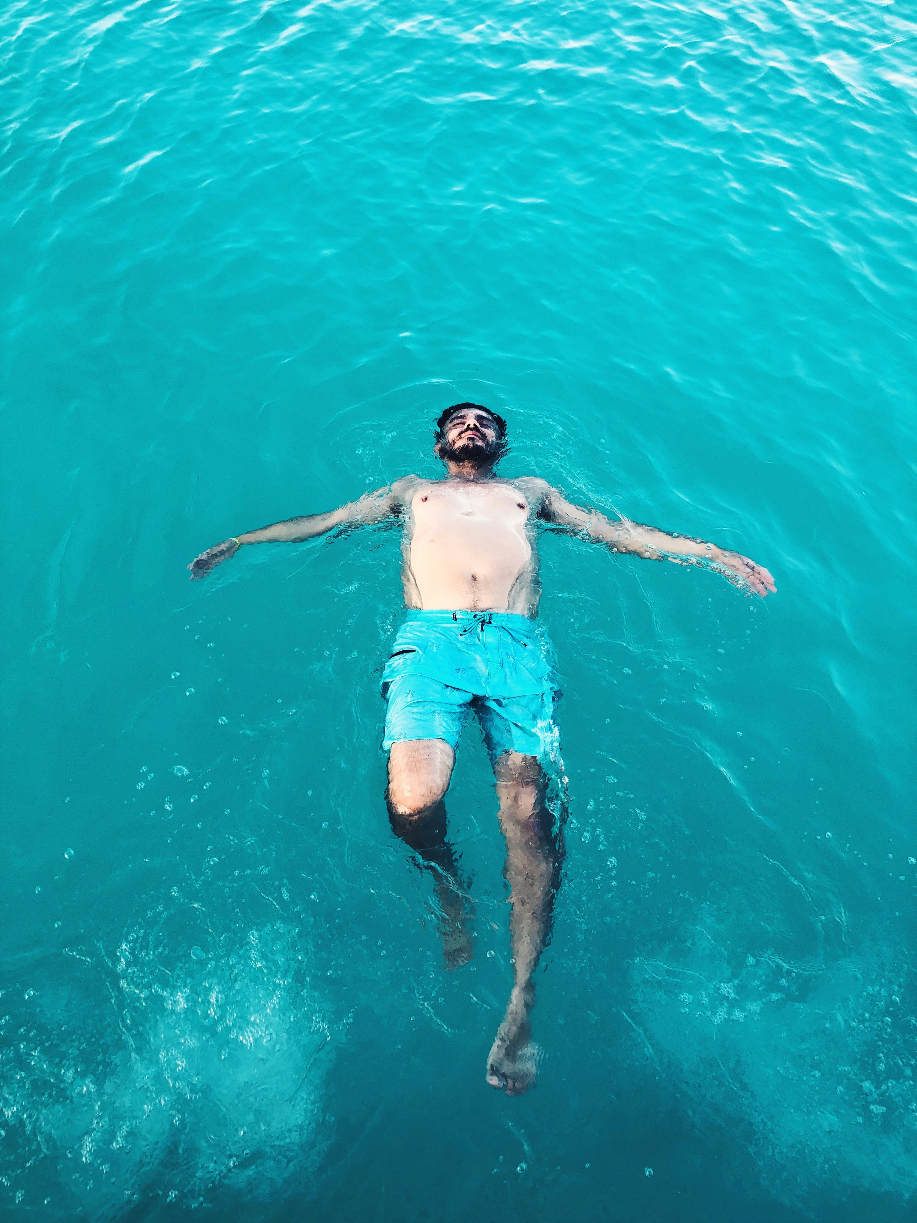 Foto de hombre en topless nadando en el cuerpo de agua durante el día ...