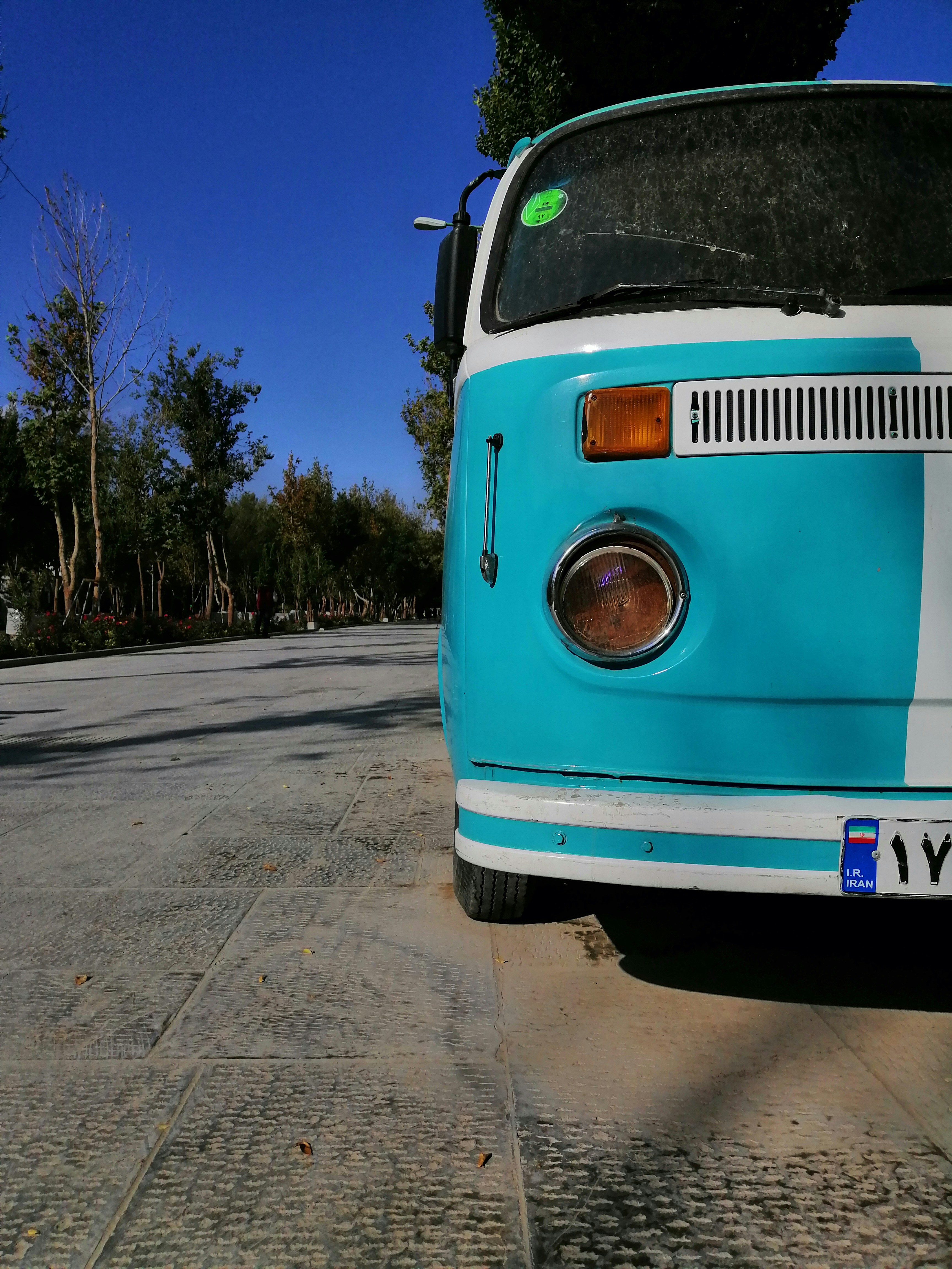 parked white and teal bus during daytime