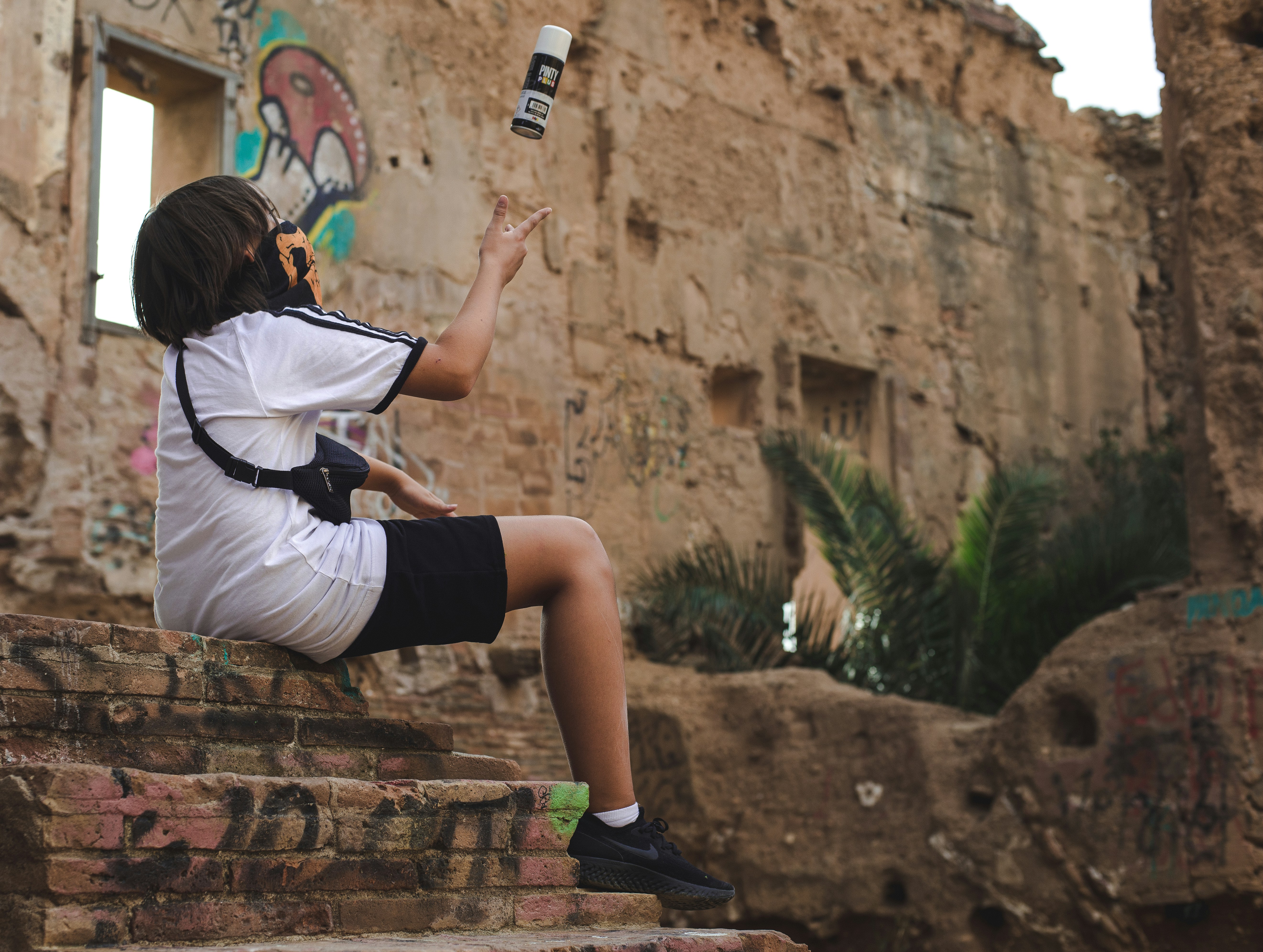 Air Toss Over Graffiti Ruins: A Youthful Moment of Play