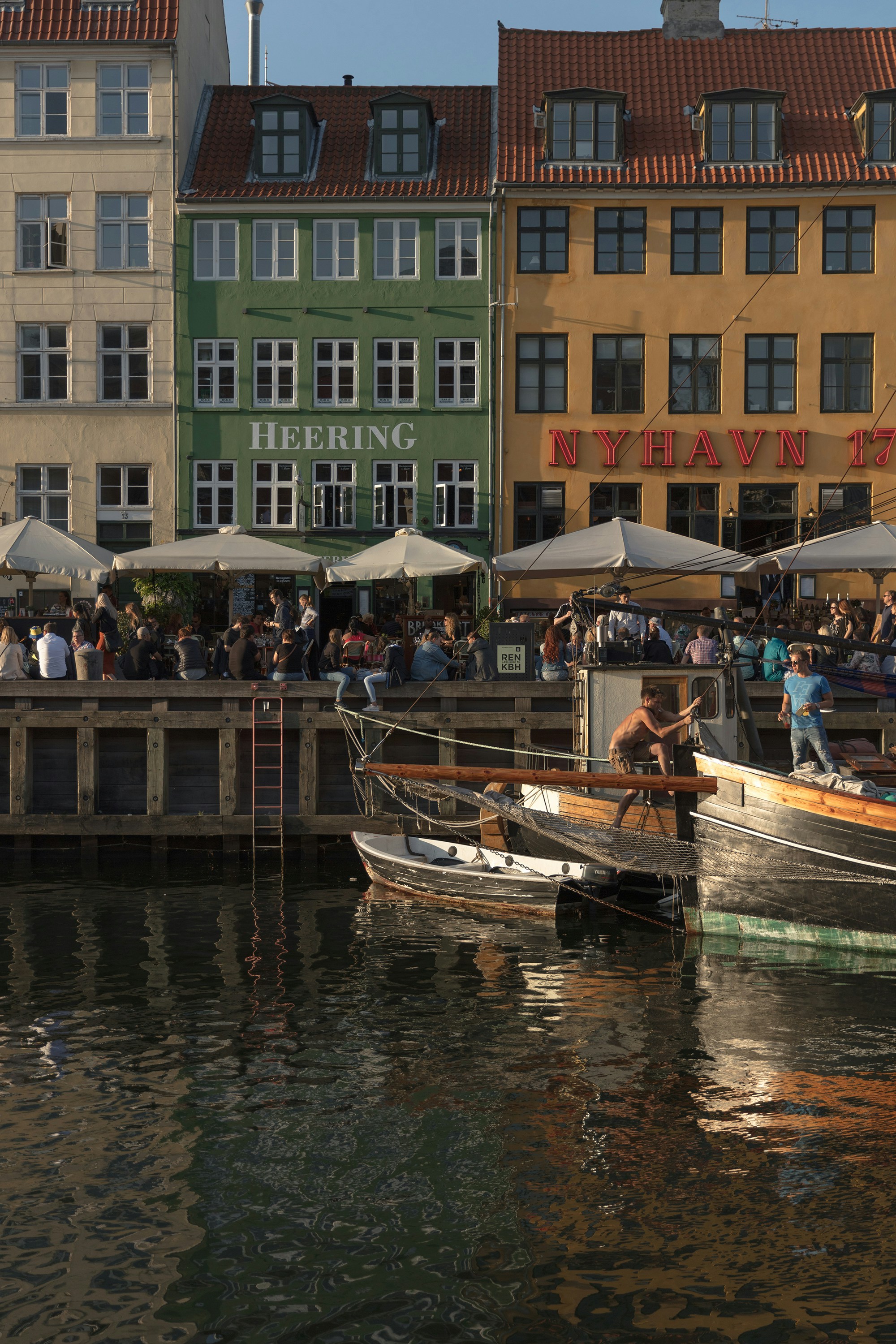 Sunlit Nyhavn Row: Colorful Facades Framing a Busy Copenhagen Quay