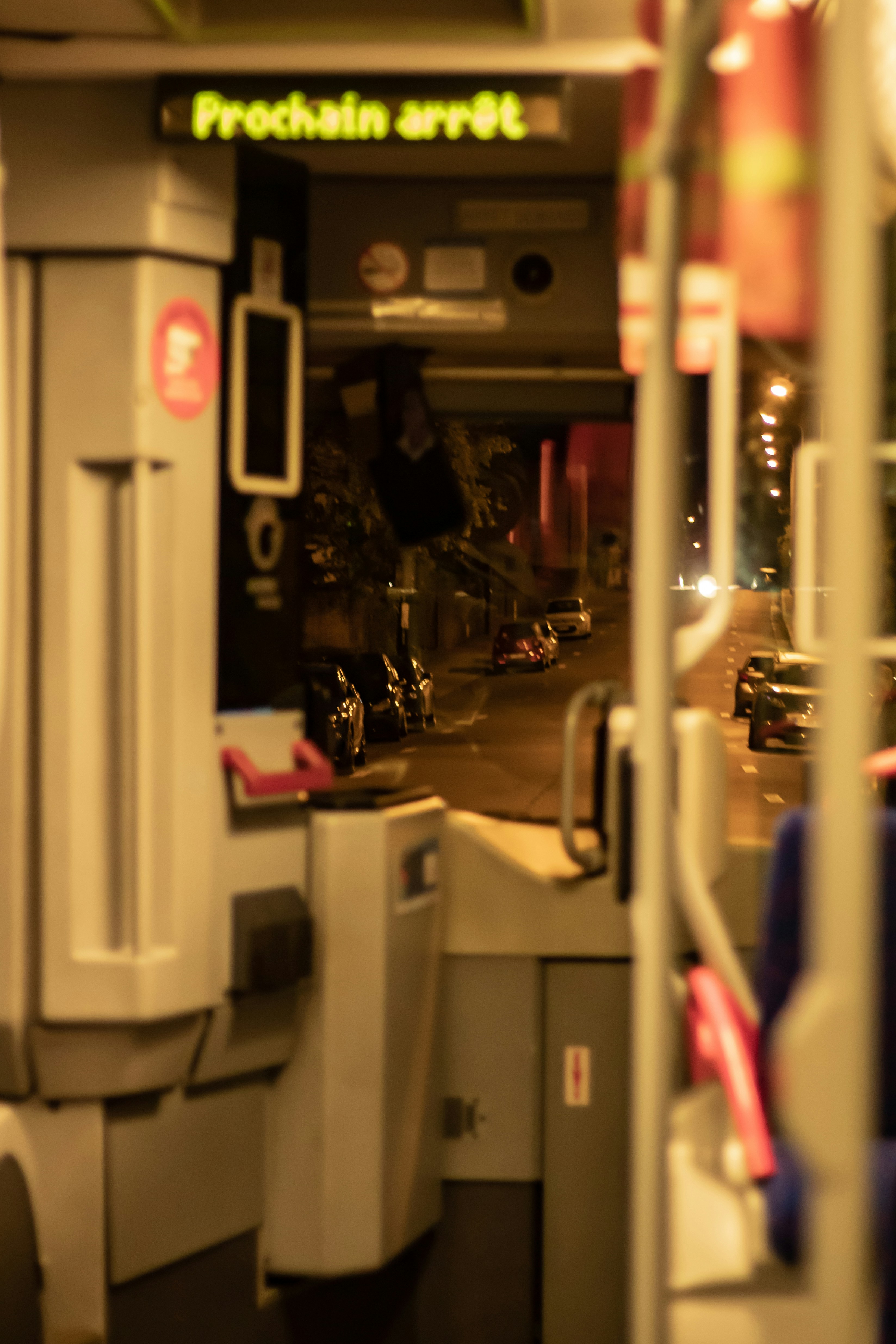 Next Stop in Neon Blur: Night Street Seen Through a Transit Window
