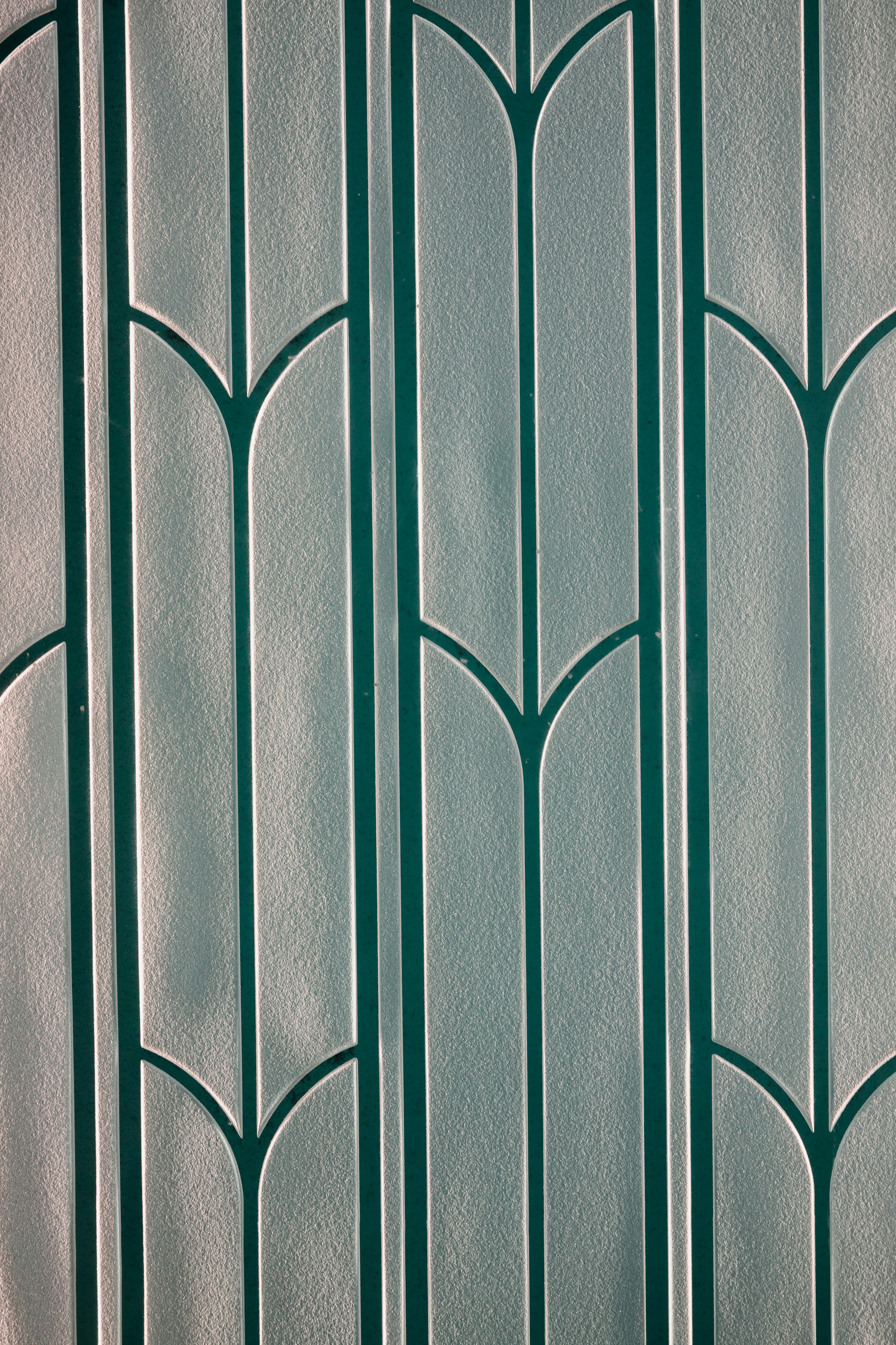 Intricate pattern of vertical lines and curves on a textured surface, showcasing a blend of geometry and subtle light play.