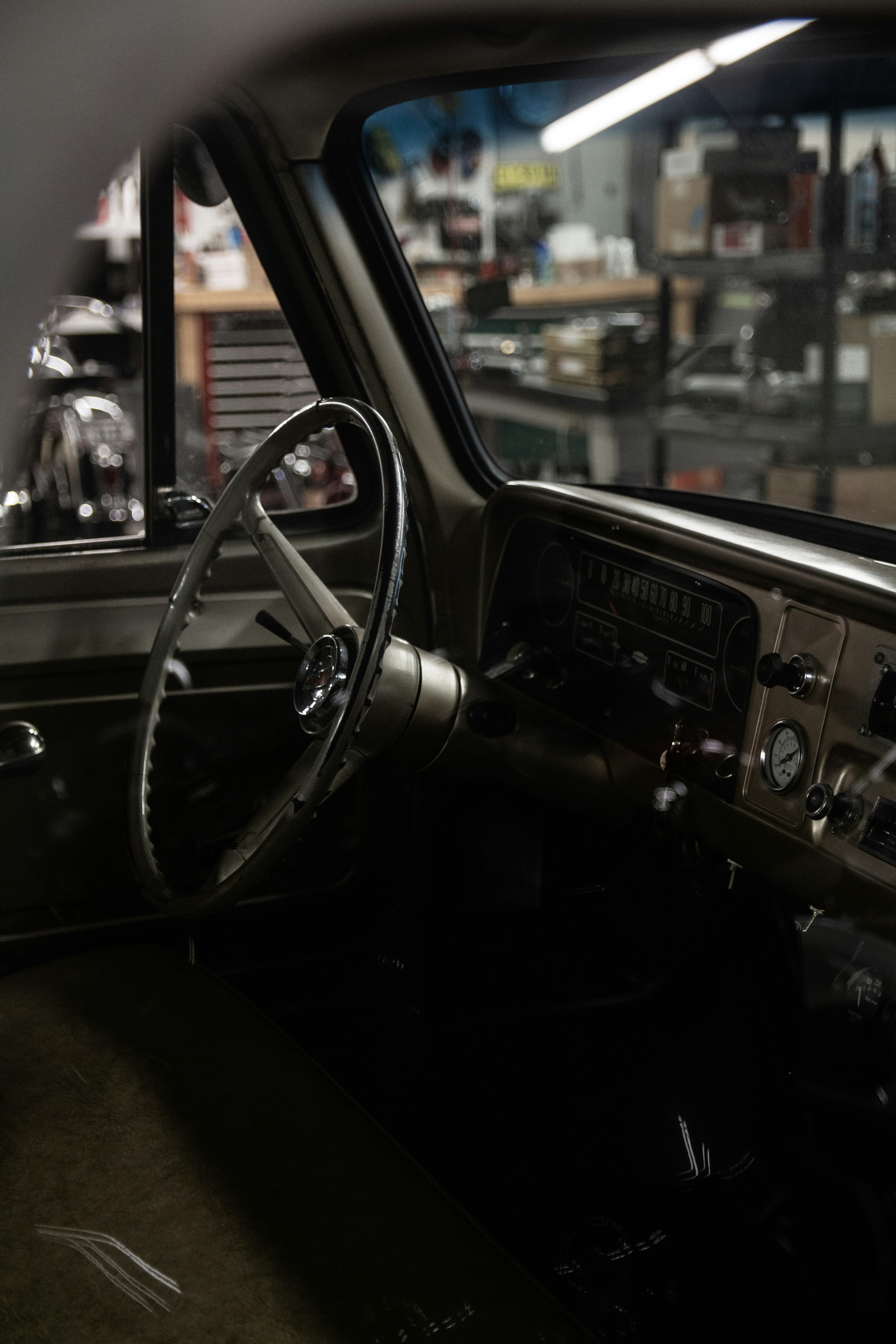 Steering Wheel Reverie: A Vintage Car's Quiet Workshop Portrait