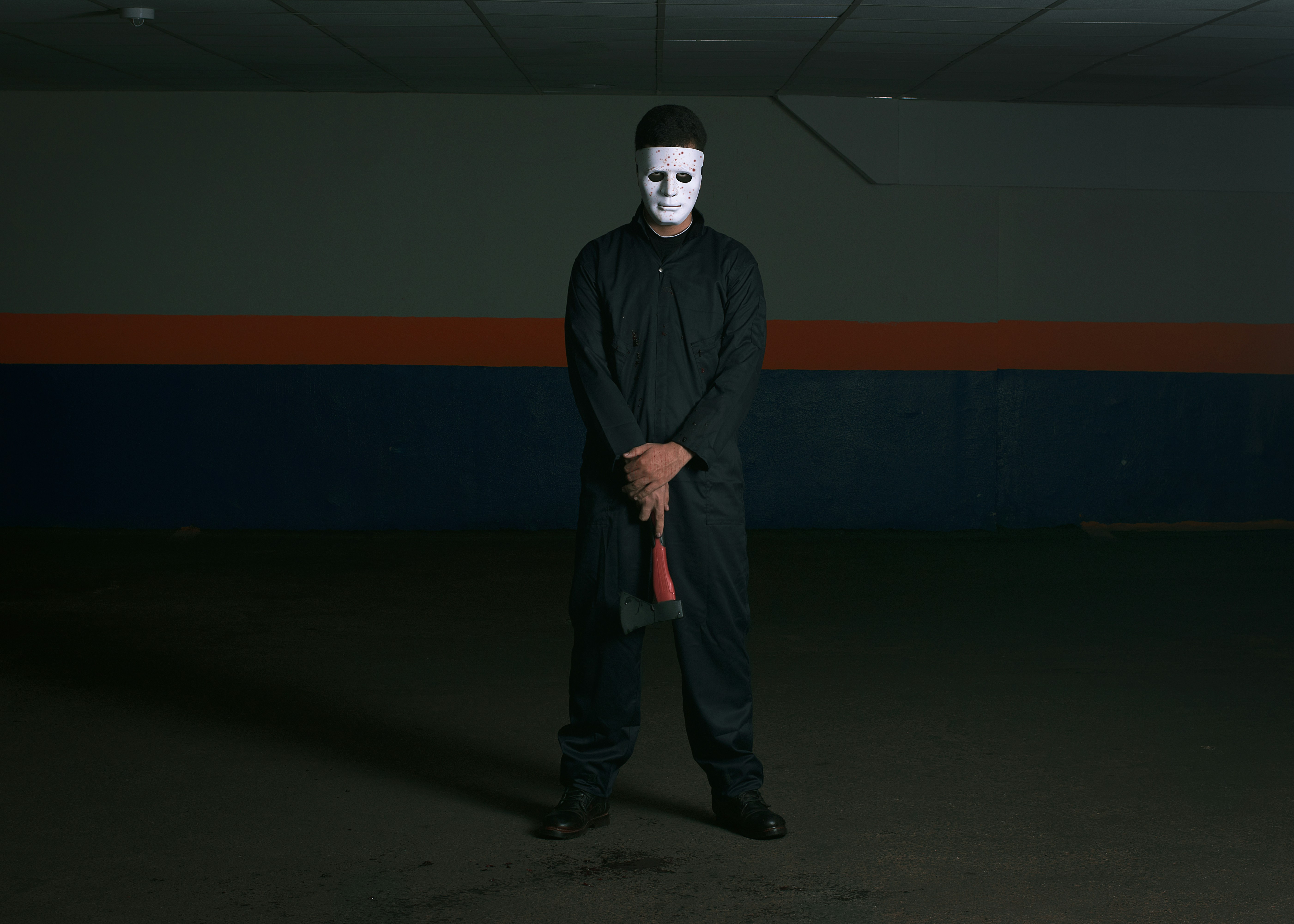 Eerie Silence: Masked Figure in Dimly Lit Space