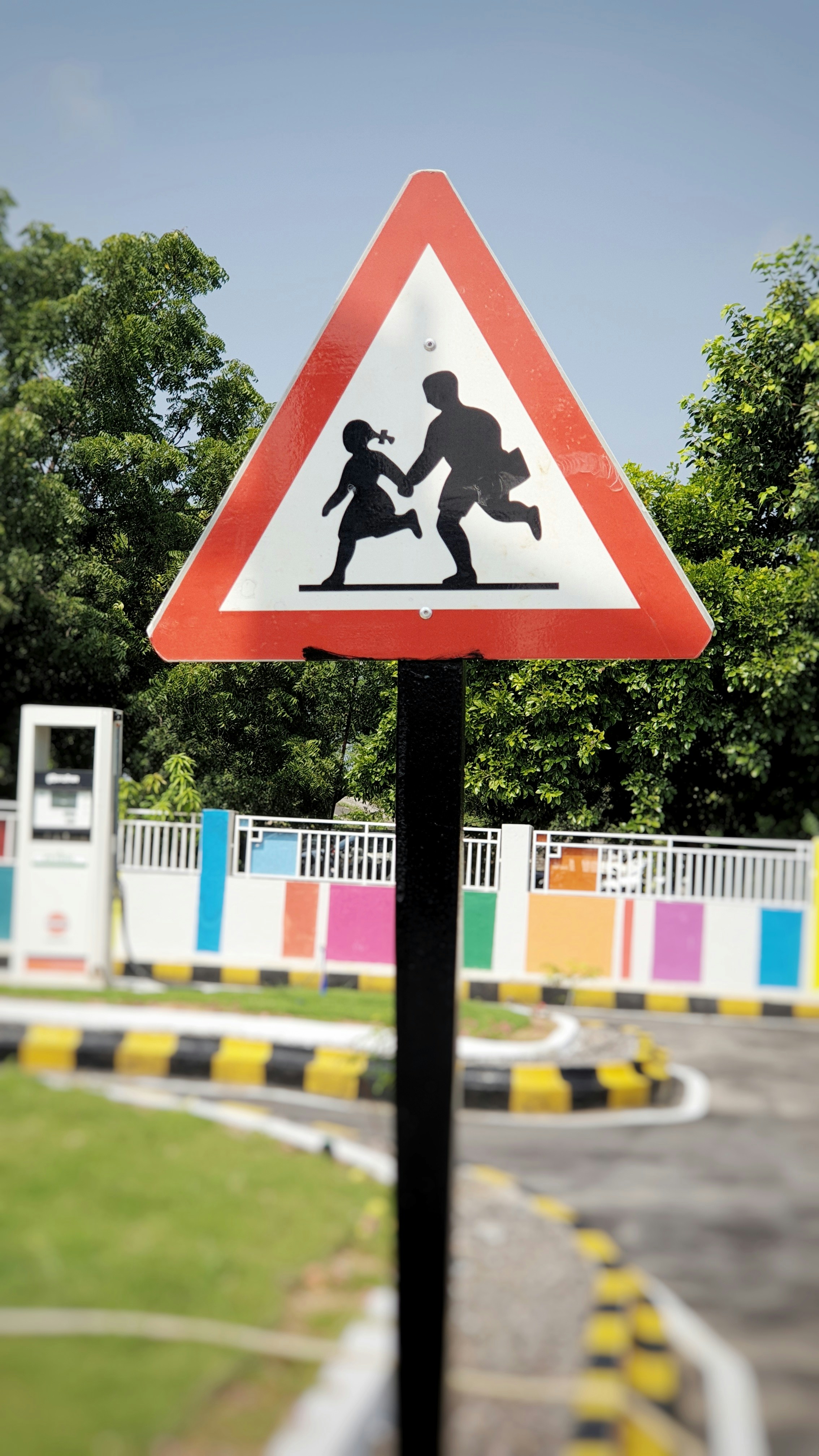 Apex of Safety: The Red Crossing Sign Framed by a Rainbow Barrier