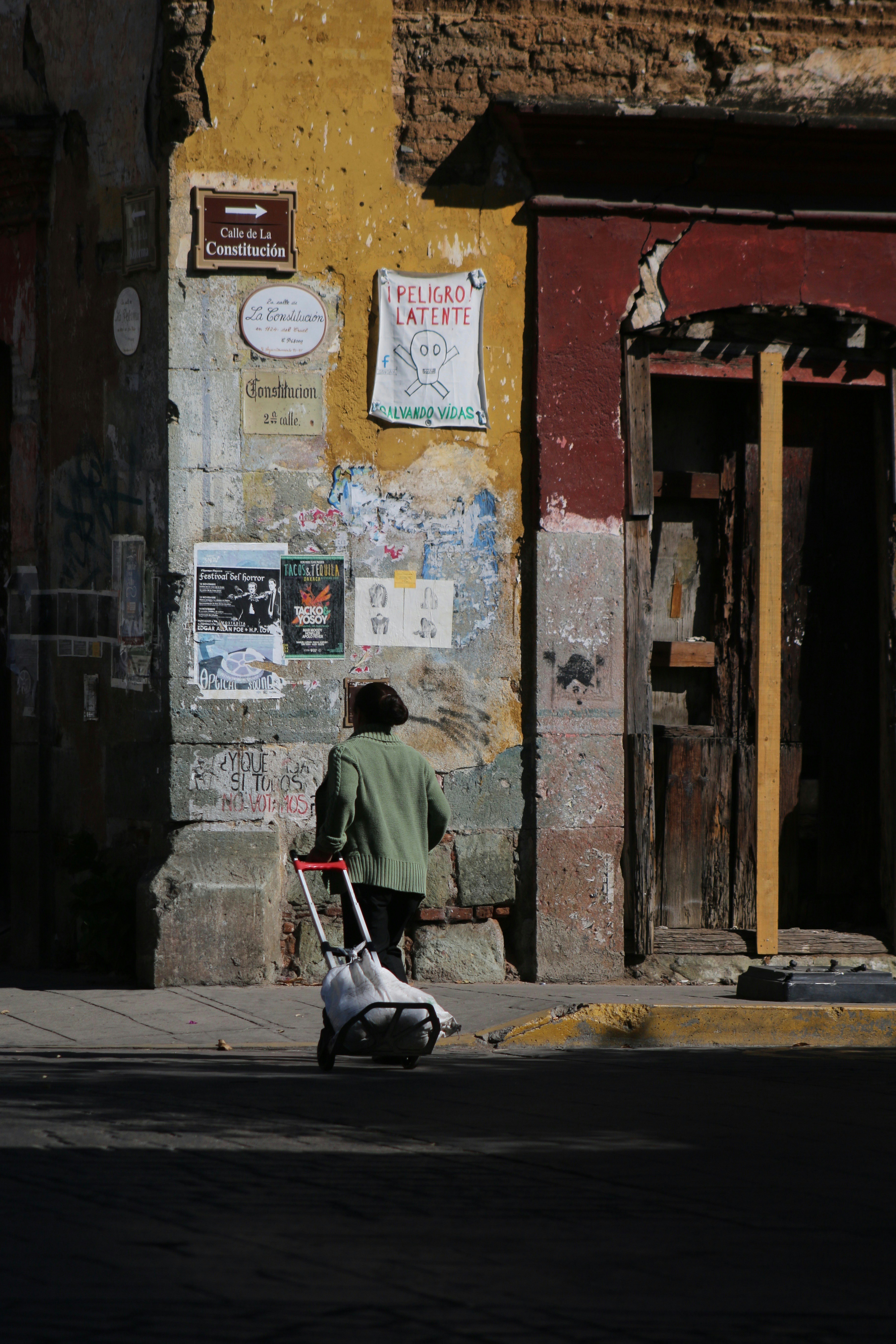 Photography of girl pulling a trolley toward building during daytime ...