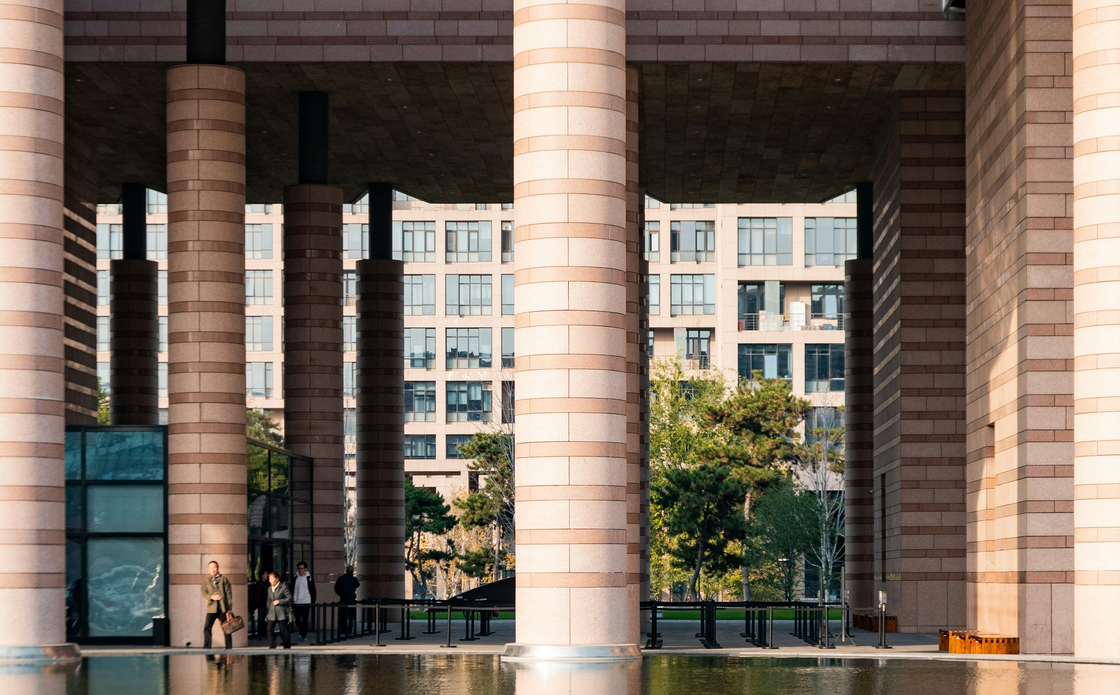 People walking beside concrete columns photo – Free Human Image on Unsplash
