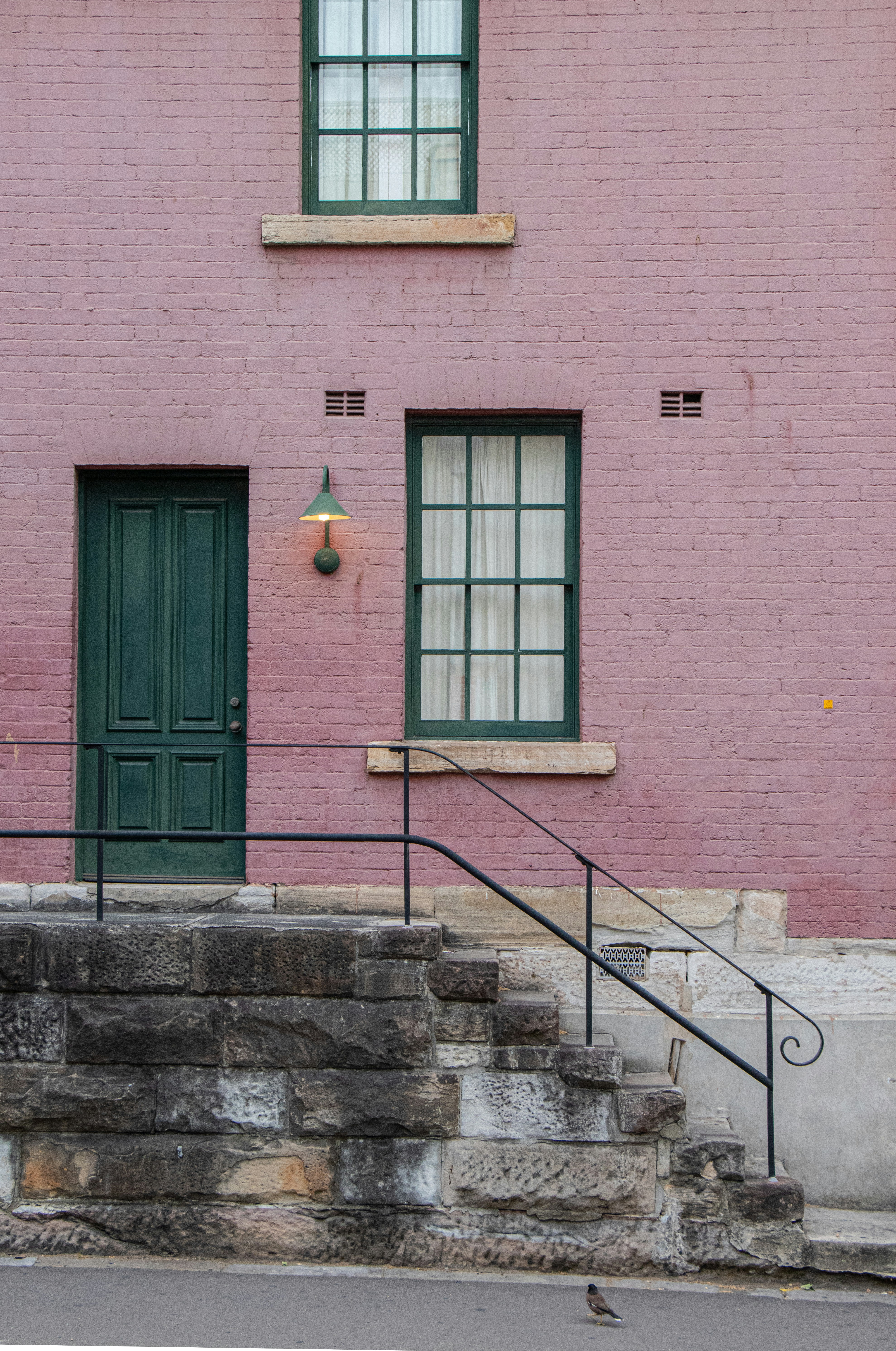 Emerald Doorway on a Pink Brick Facade: A Quiet Staircase Portrait