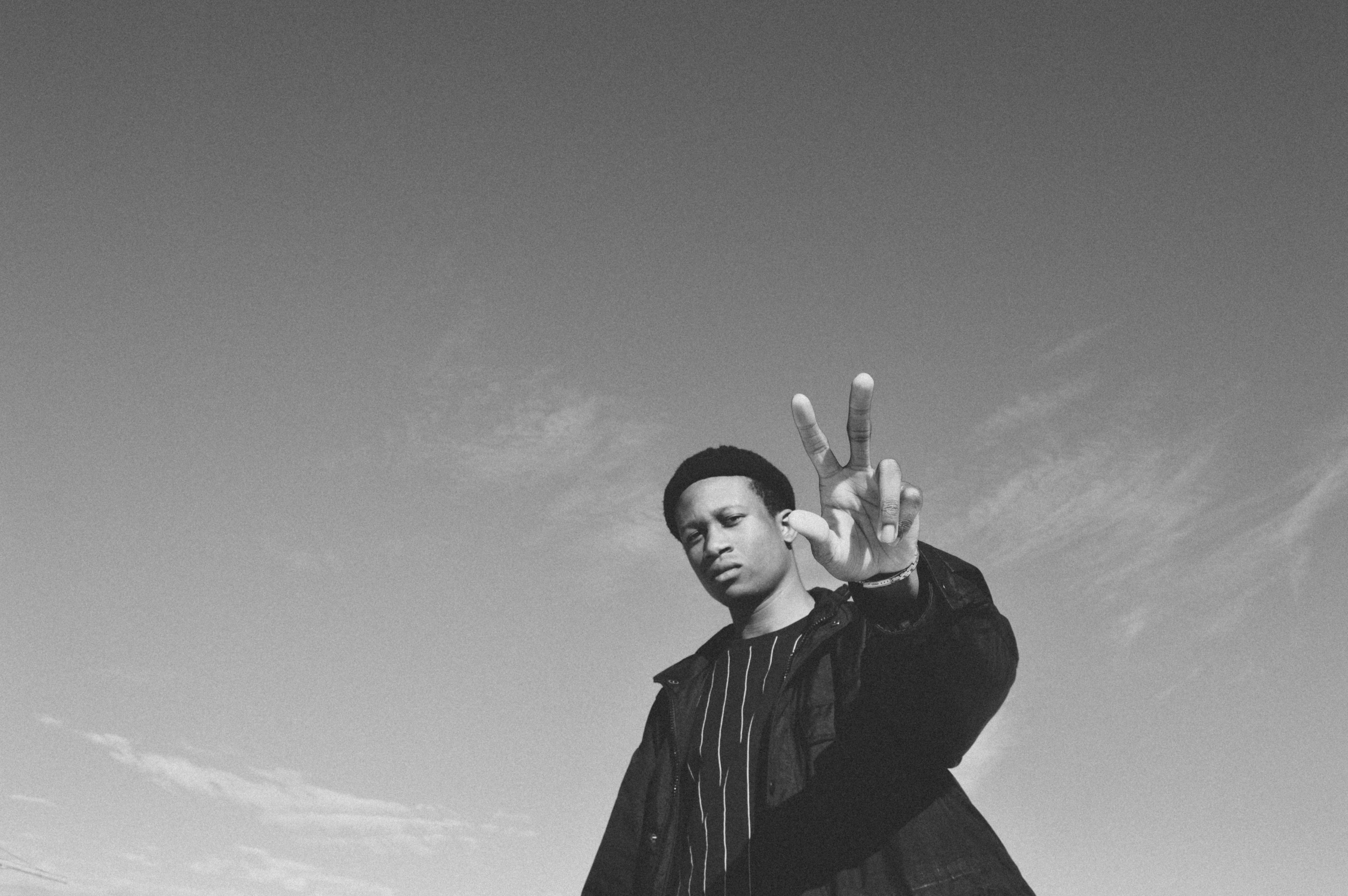 Grayscale photography of standing man holding out hand sign photo ...