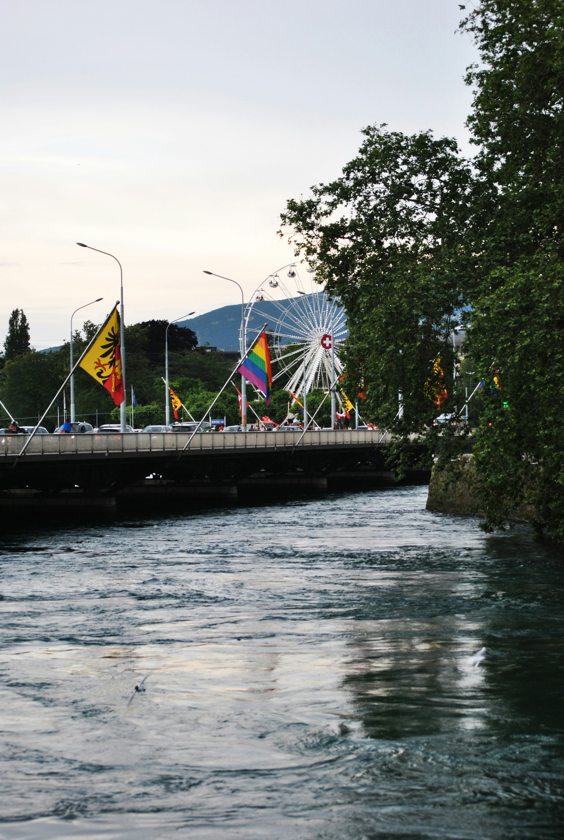 Rainbow Flags over the River: A Festive Bridge Scene