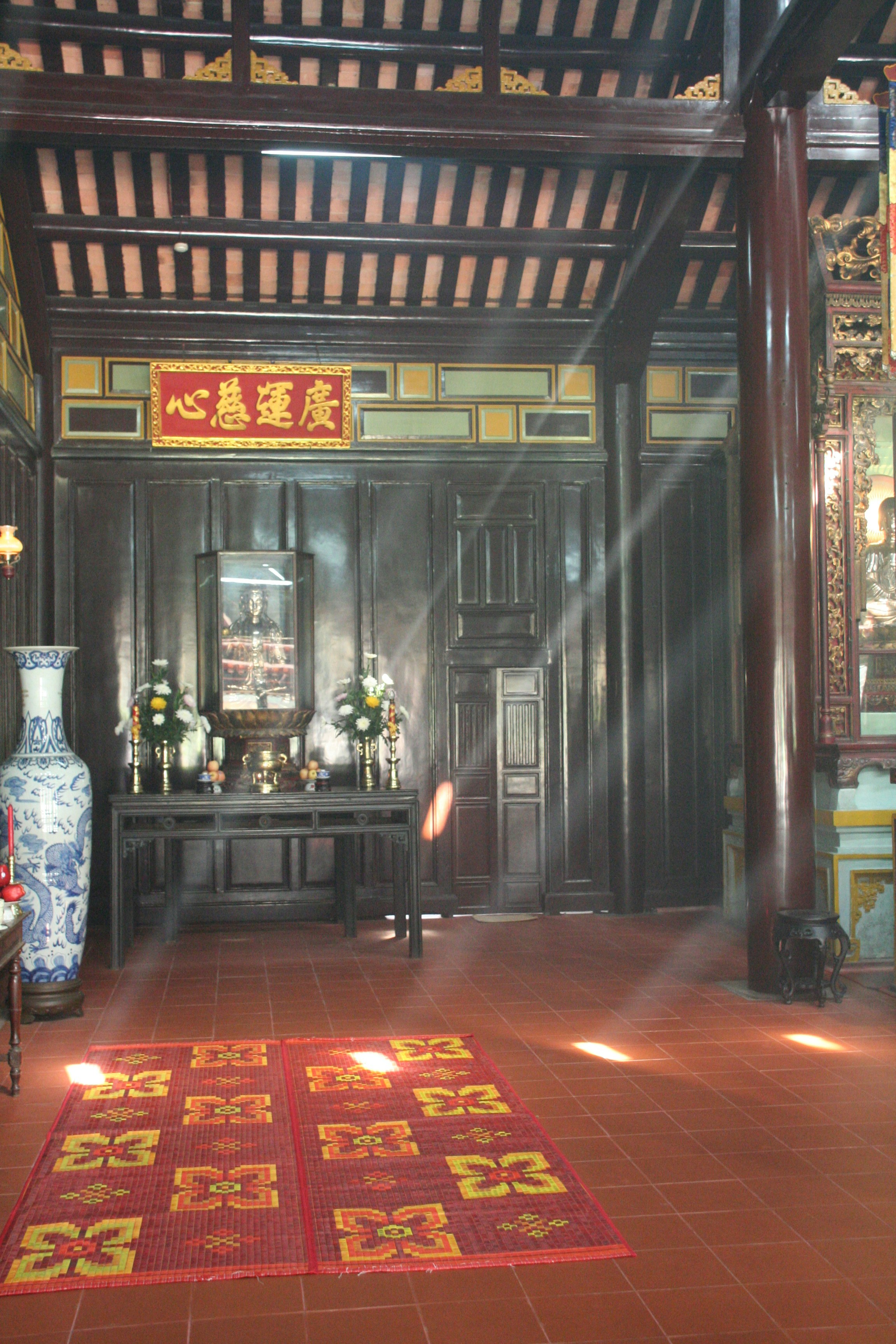Silhouetted shrine: garden of lanterns and carved altar in temple hall