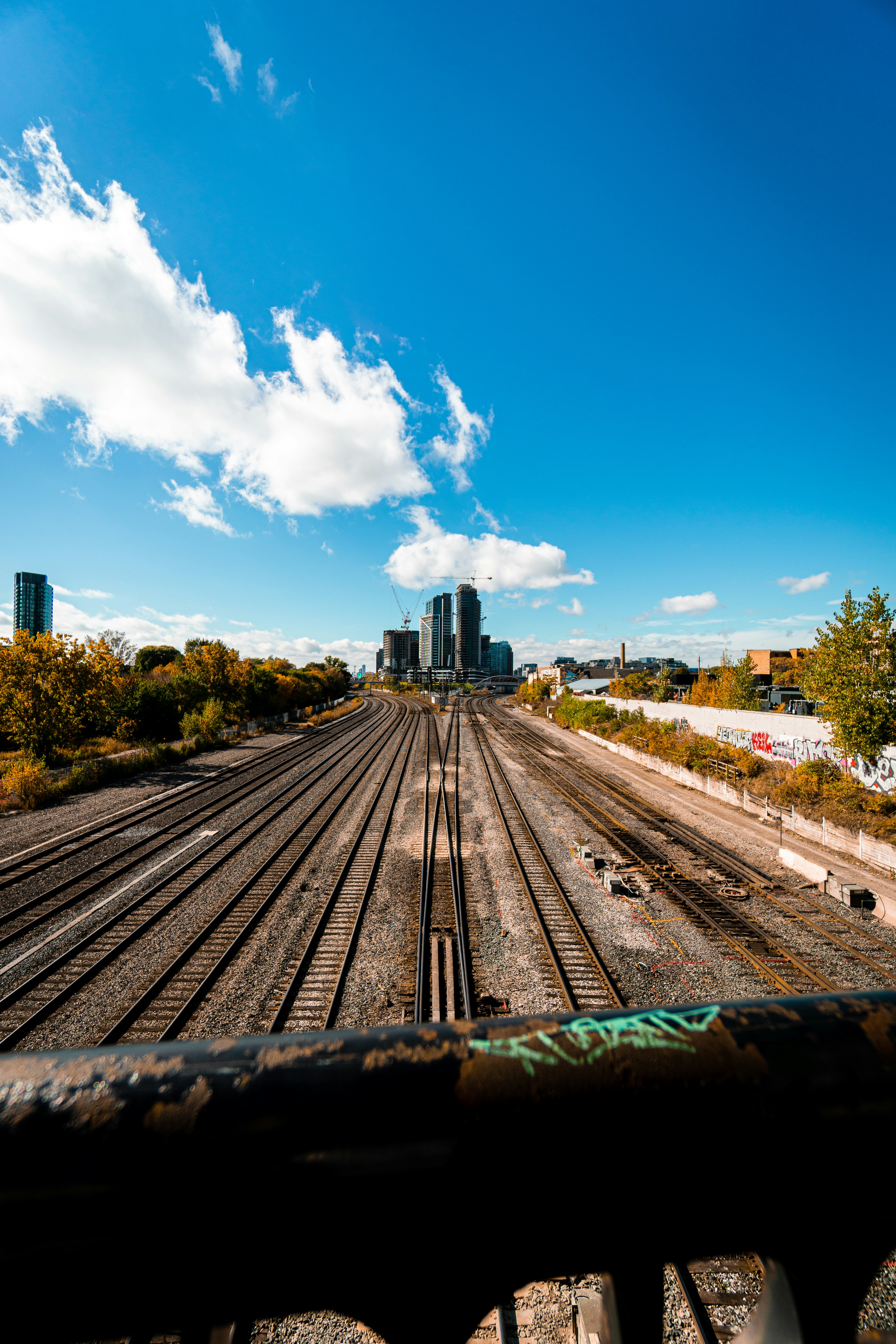 Rails Converge Toward a Glass-City Skyline