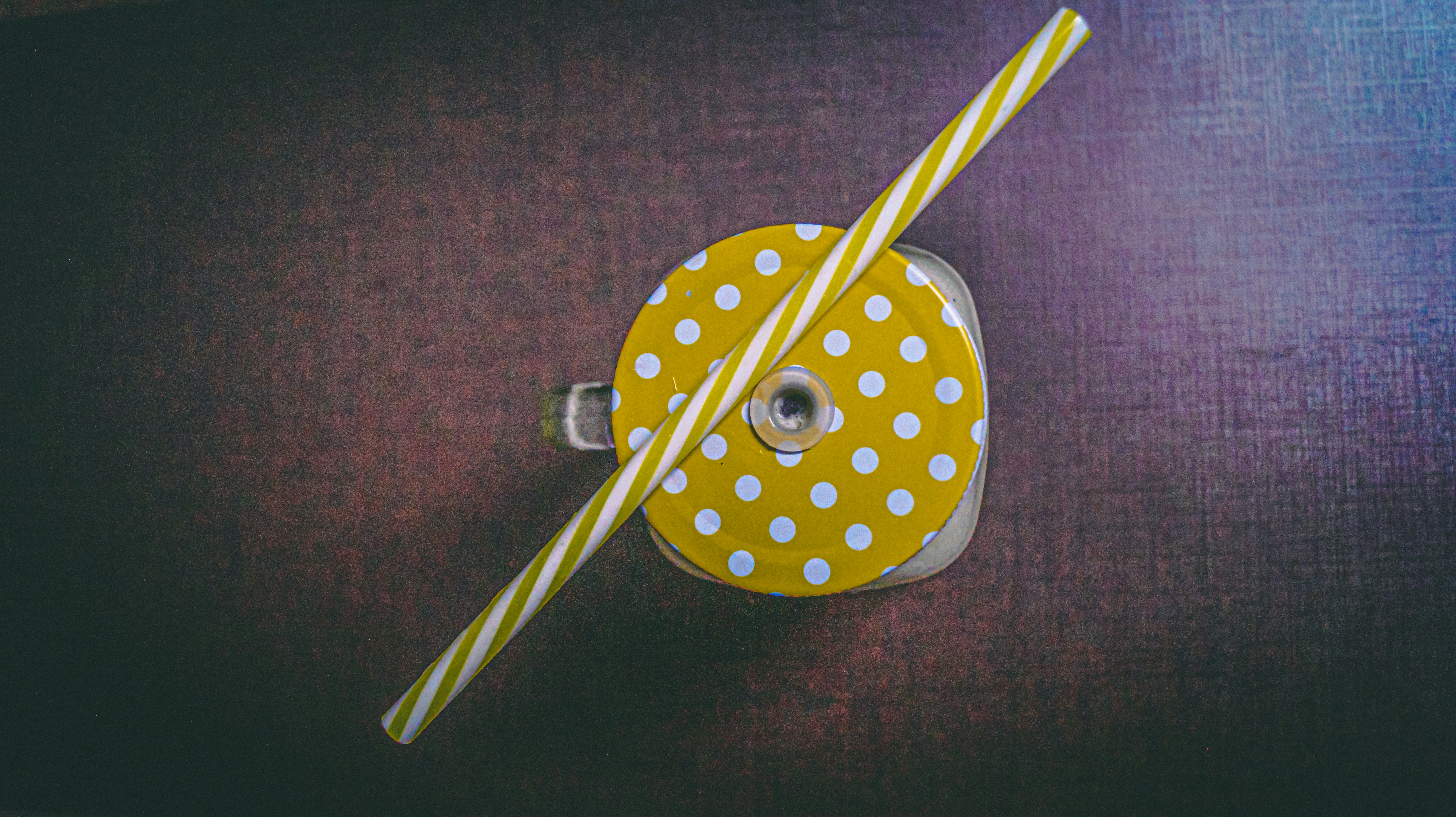 white and yellow striped straw on top of clear glass mug