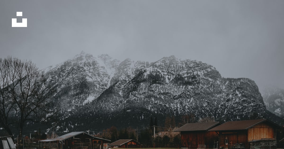 昼間は緑の野原を眺める山に茶色の木造住宅の写真 Unsplashのガルミッシュ・パルテンキルヒェンの無料画像