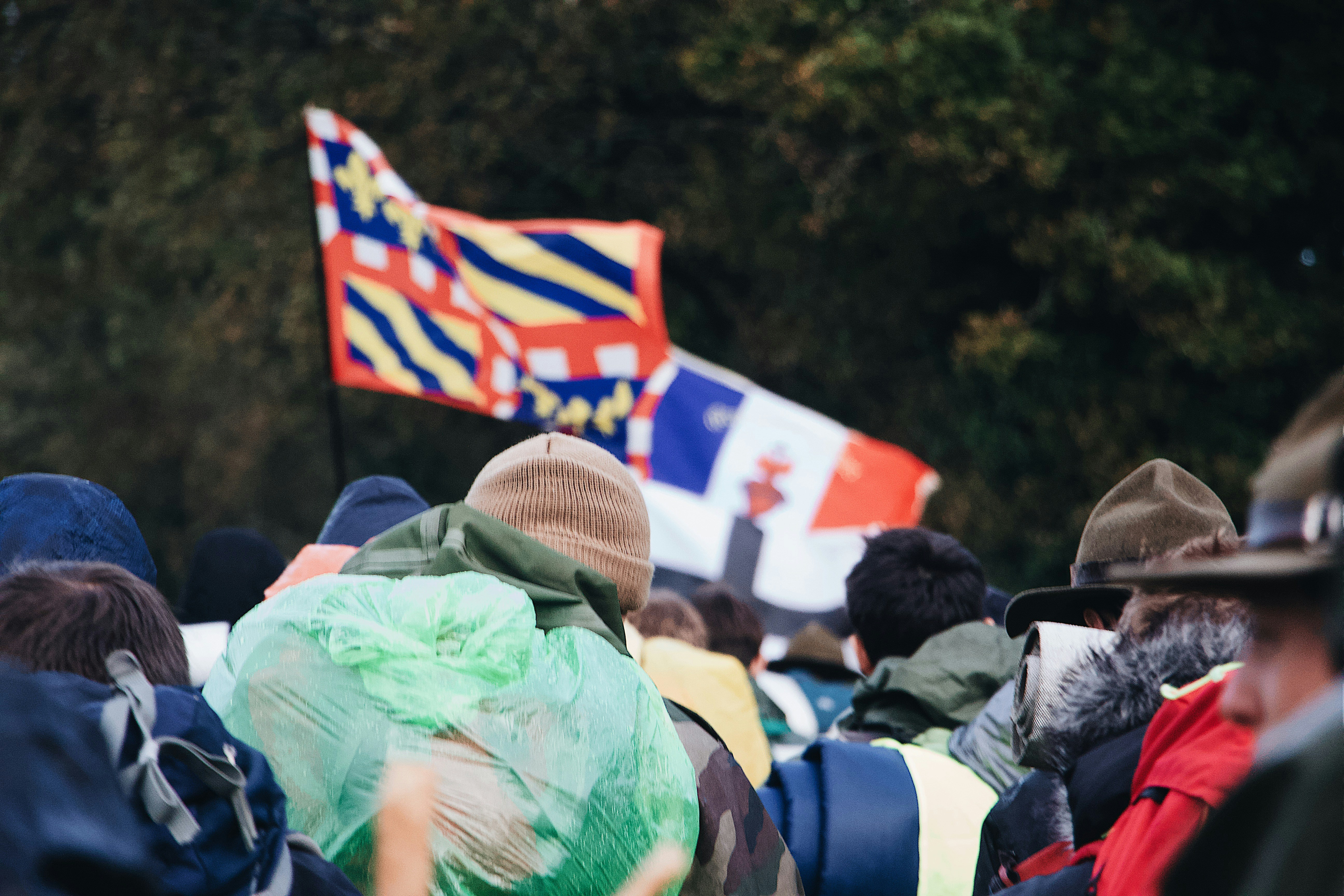Flags Above the Crowd: A Sea of Hoods and Helmets Beneath Collective Spirit