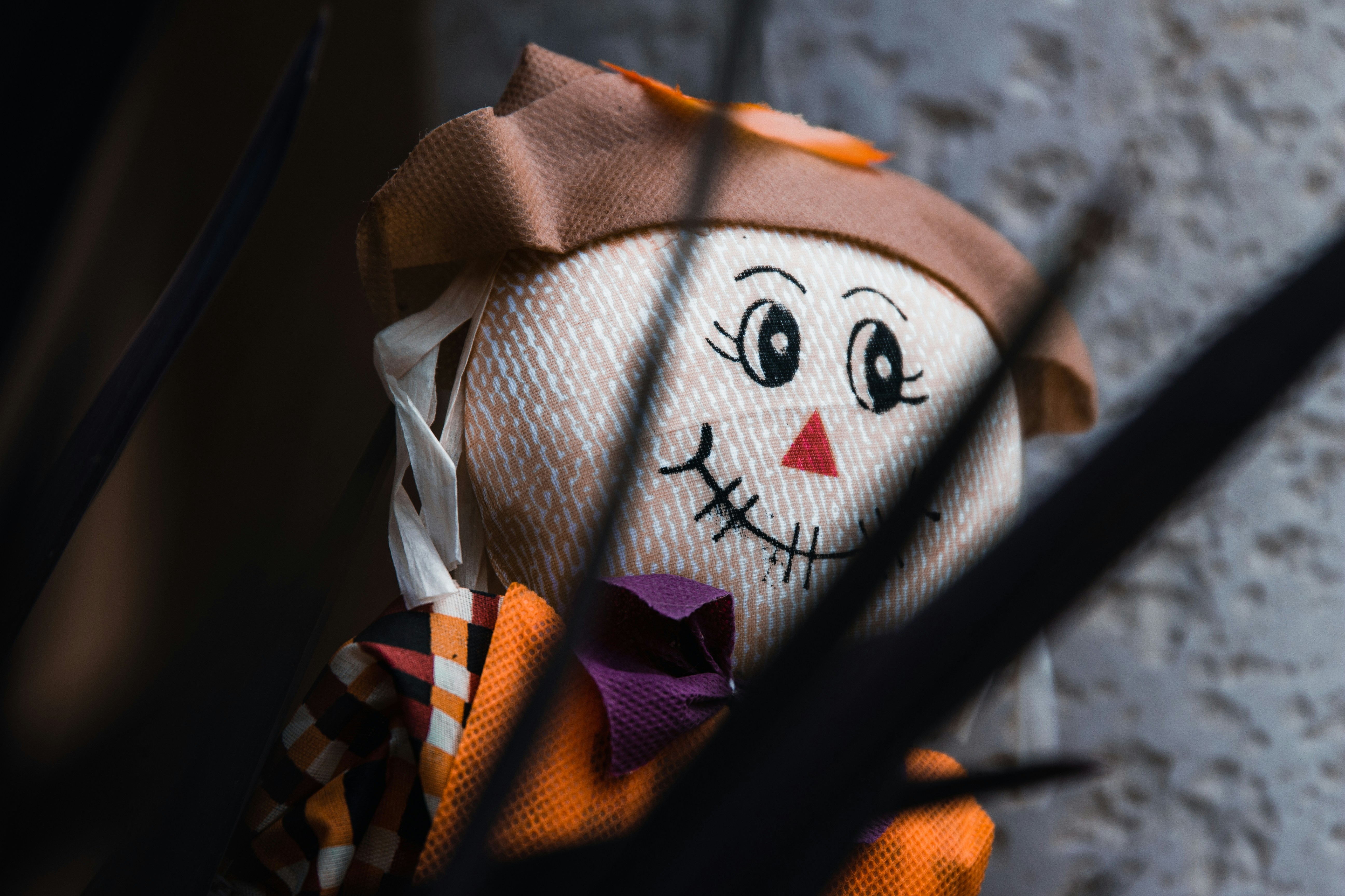 Pumpkin-faced Plush Guarded by Shadows in a Dim Corner