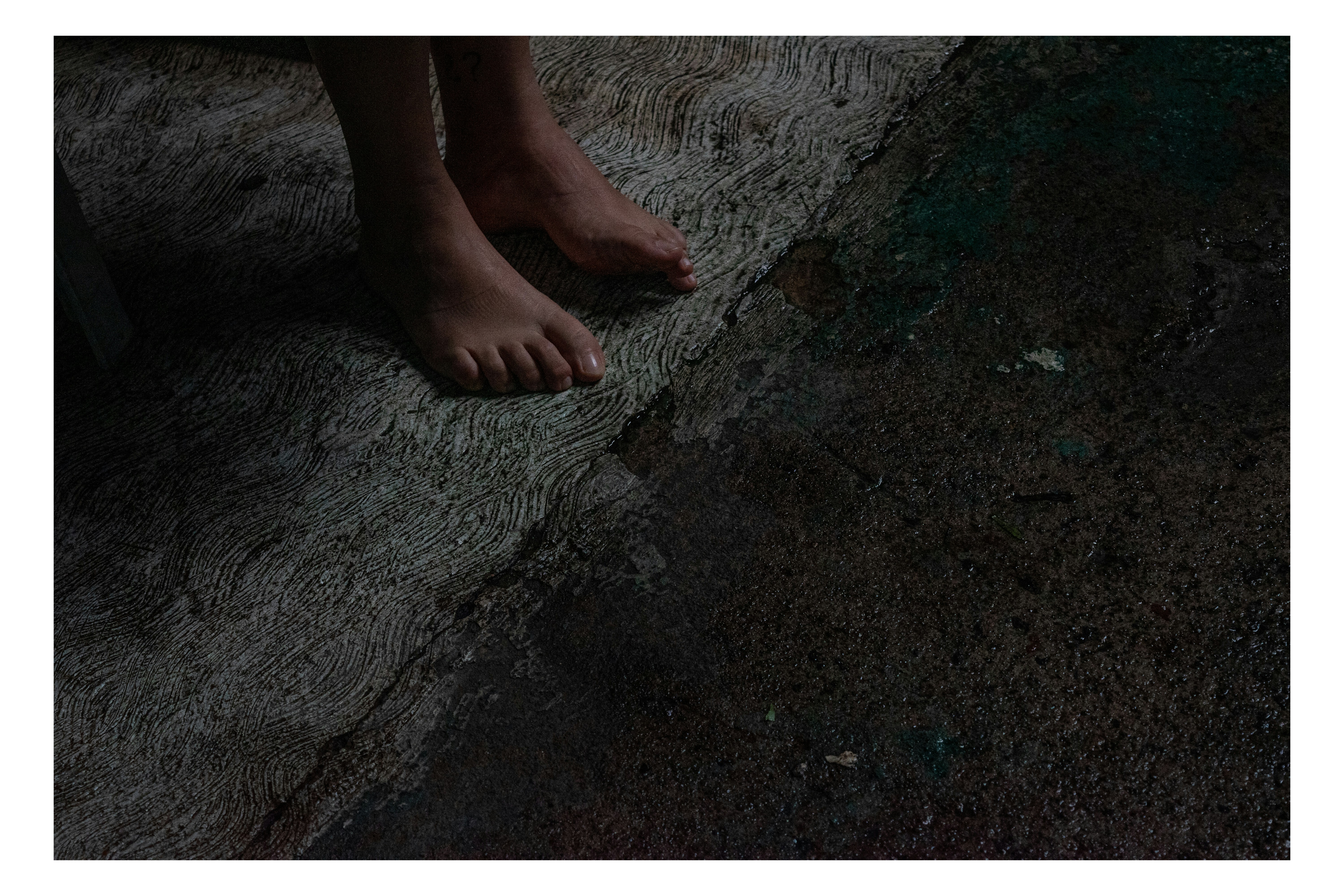 barefoot person standing on gray surface