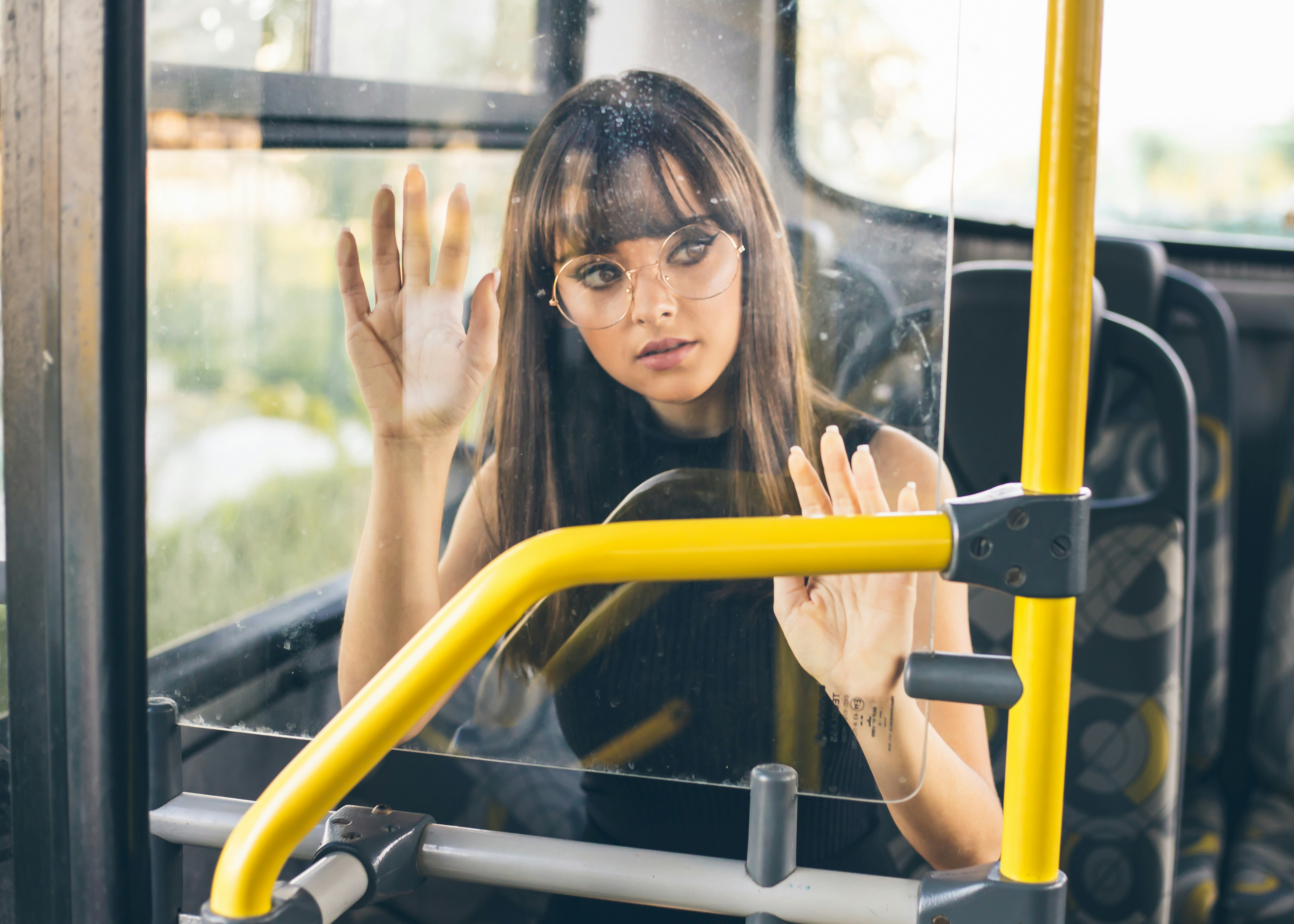 Between Glass and Yellow Rails: A Bus Portrait of Quiet Curiosity
