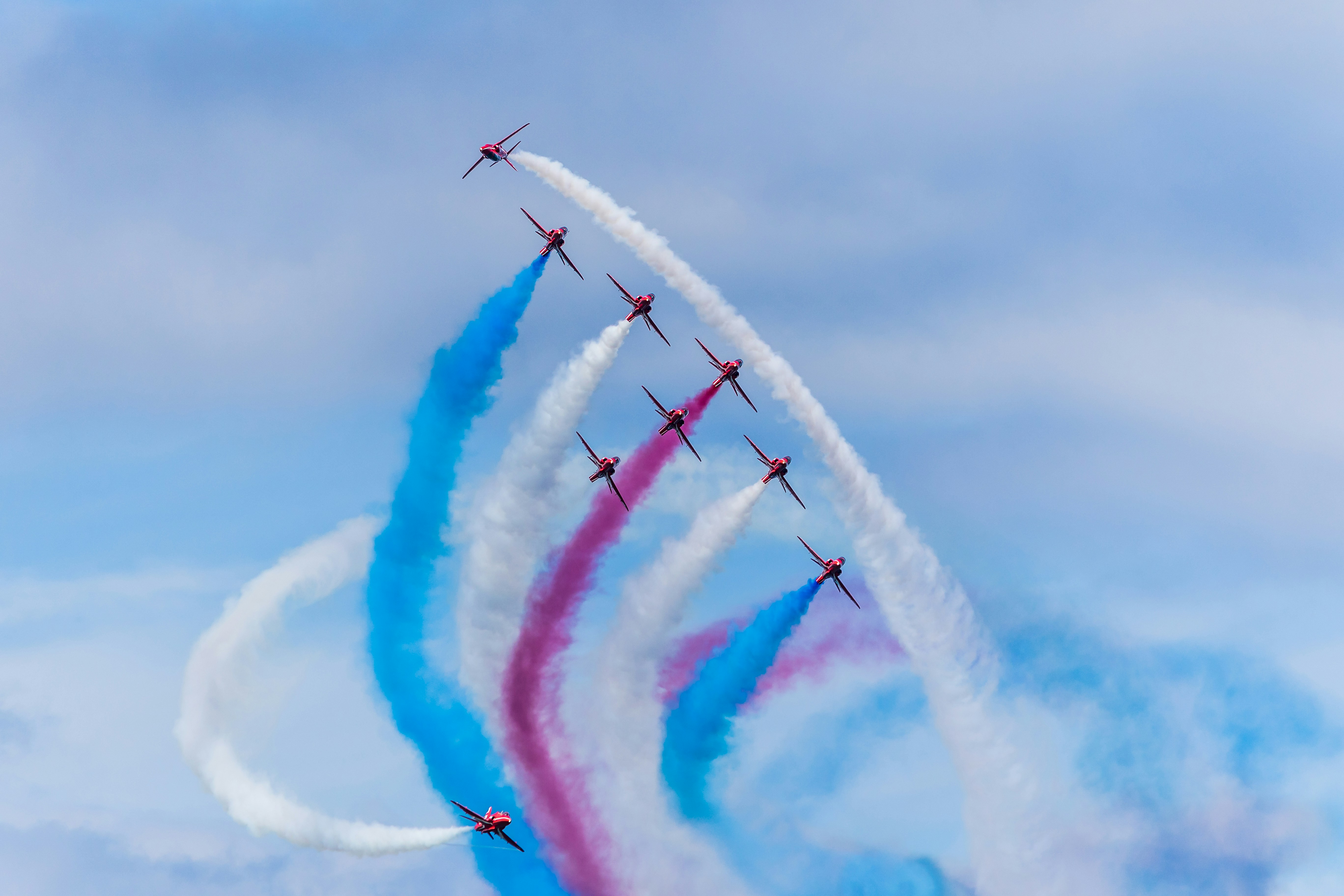 Nine red aircraft in an air show under white and blue sky during ...