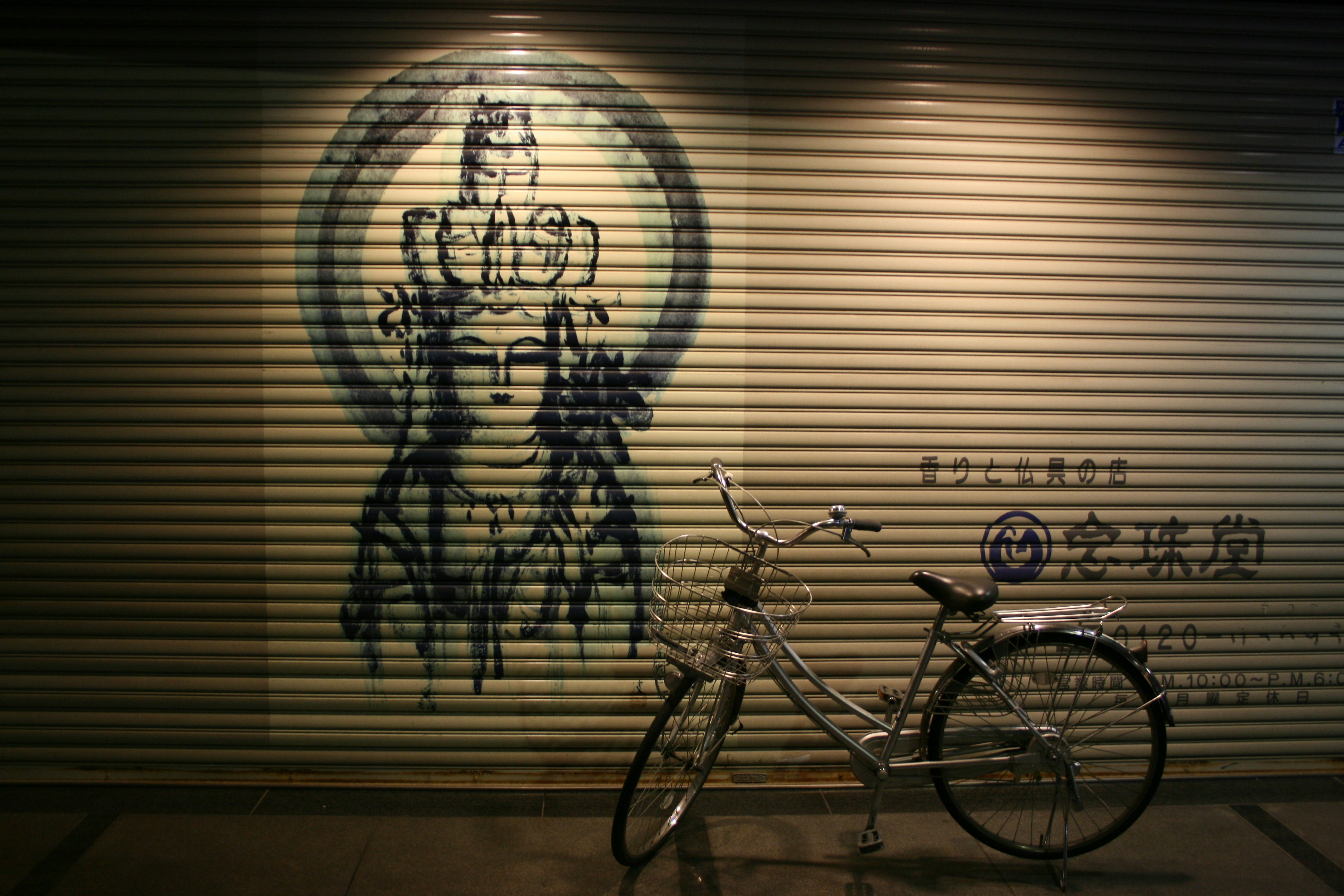 A vintage bicycle rests against a wall adorned with a serene mural, capturing a moment of tranquility in an urban setting.