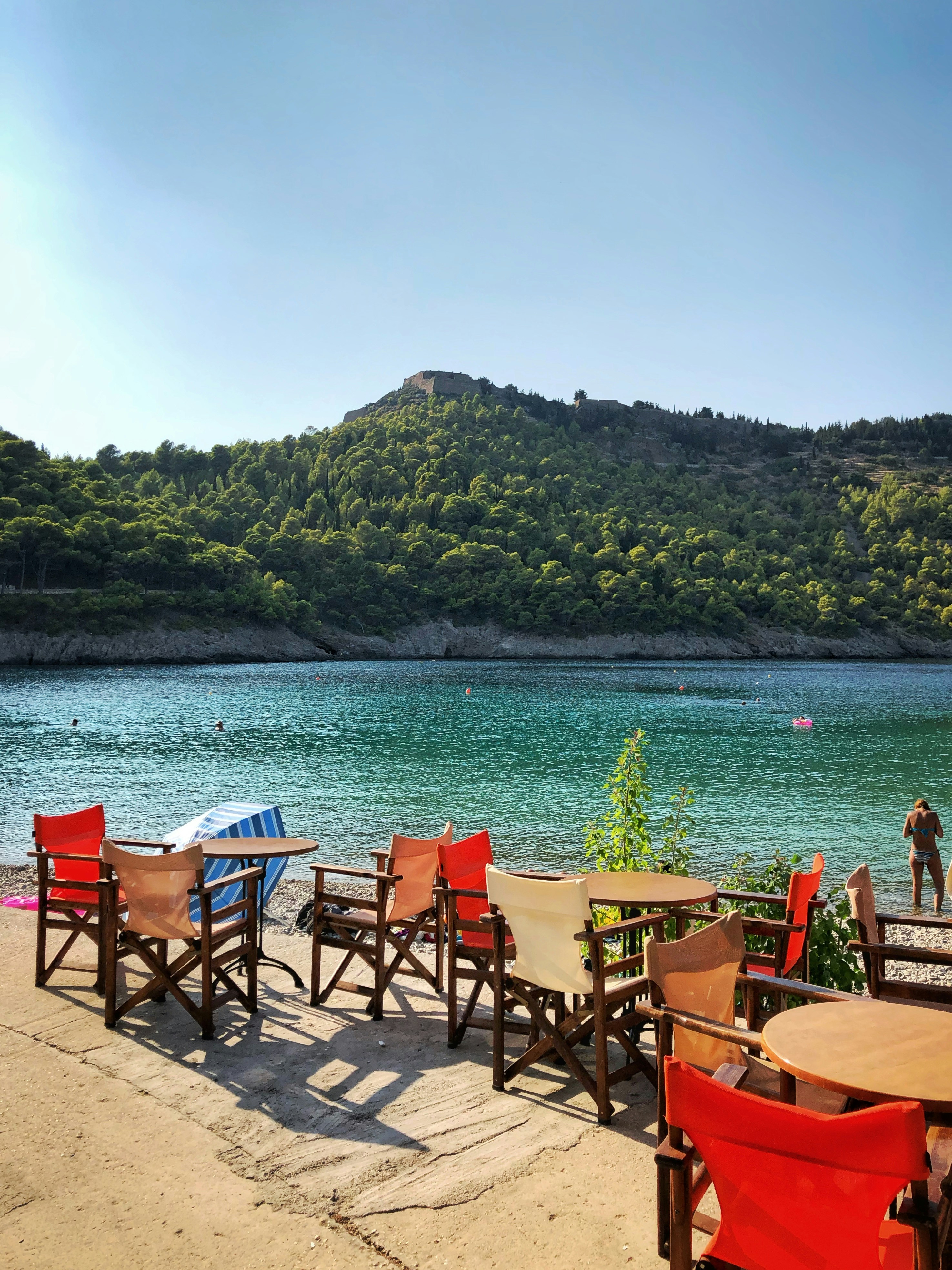 Chairs and tables near body of water and mountain photo – Free Greece ...
