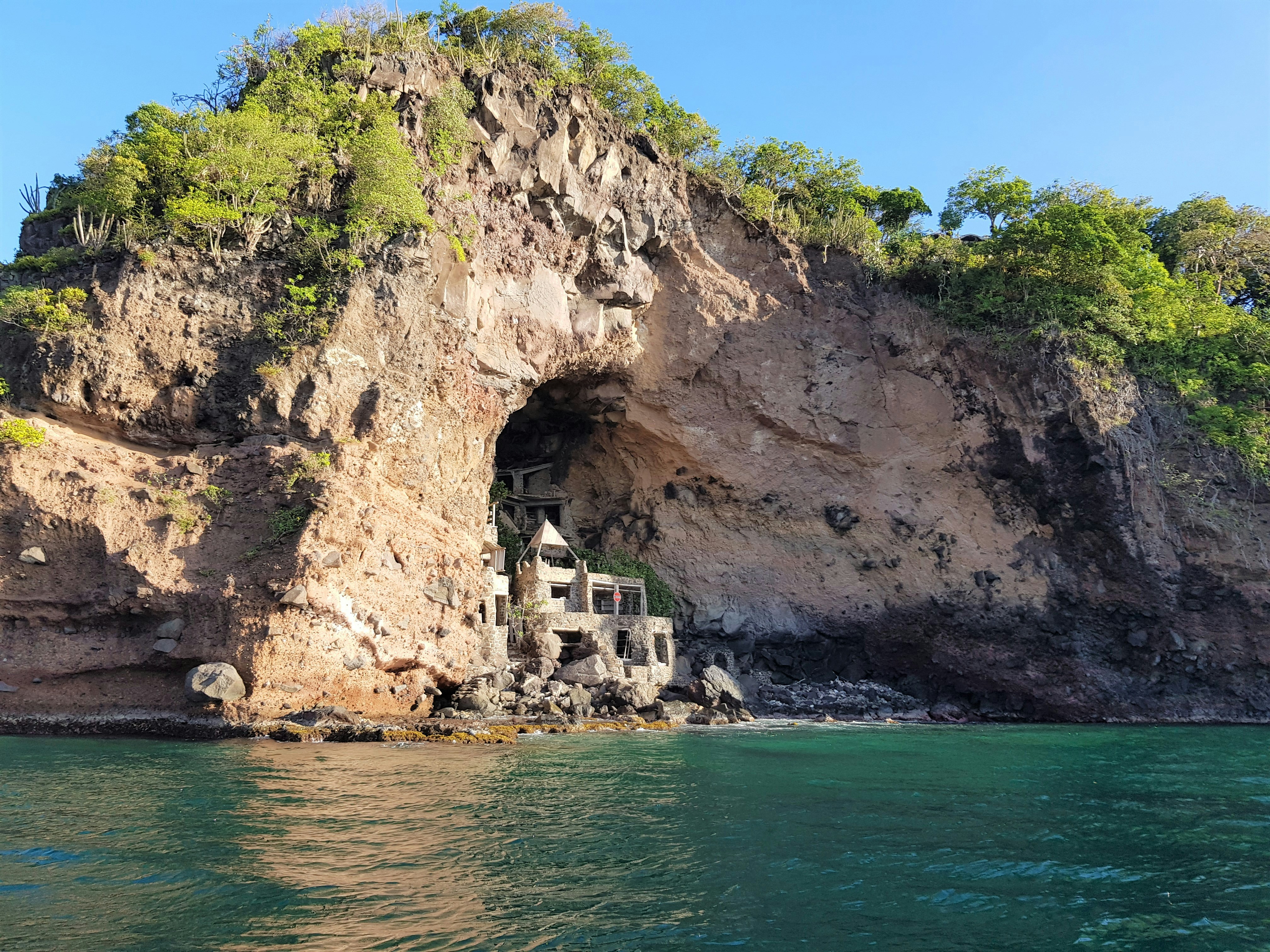 Concrete structure in cave beside body of water photo – Free Shoreline ...