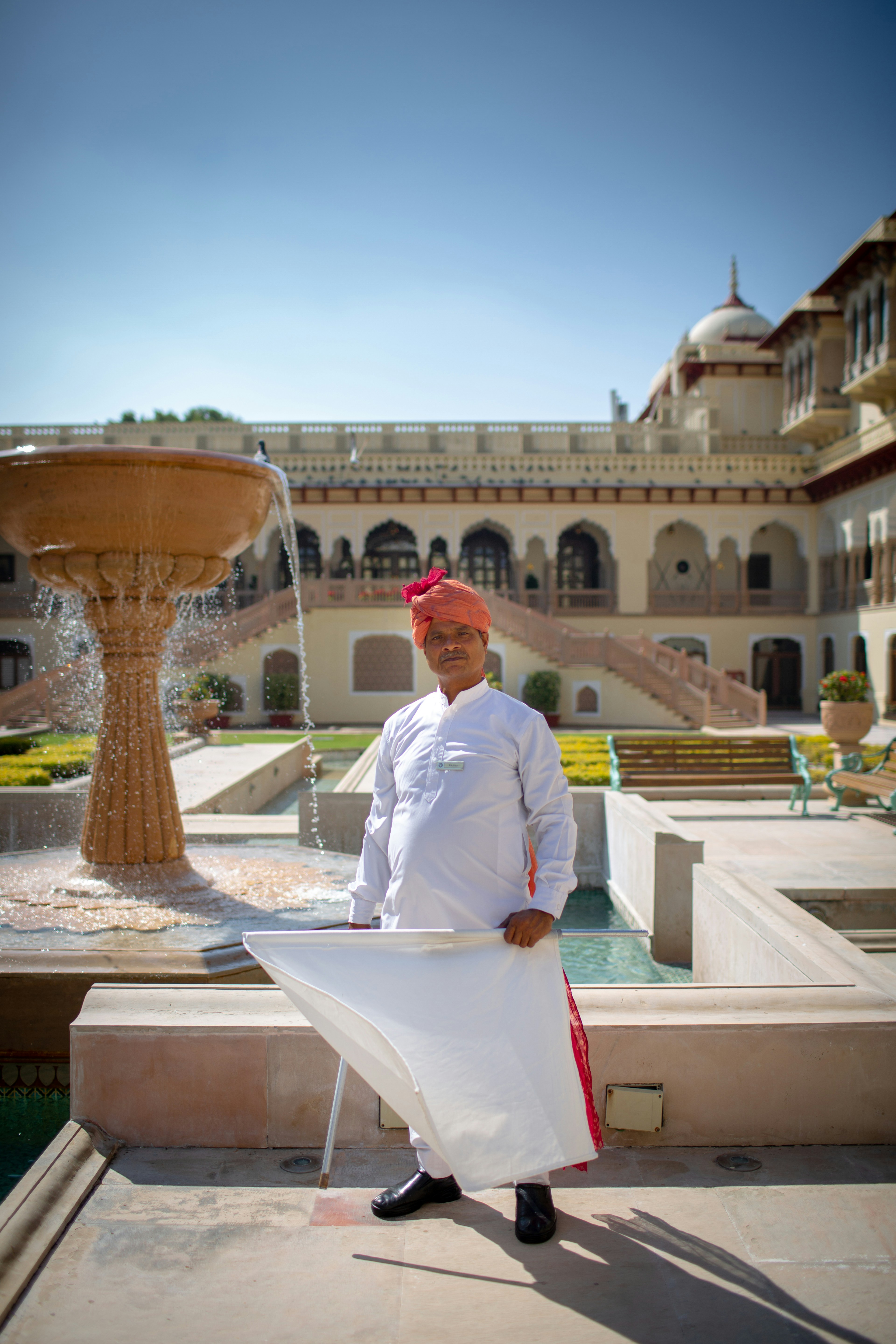 Royal Attire by the Fountain: A Portrait in a Palace Courtyard