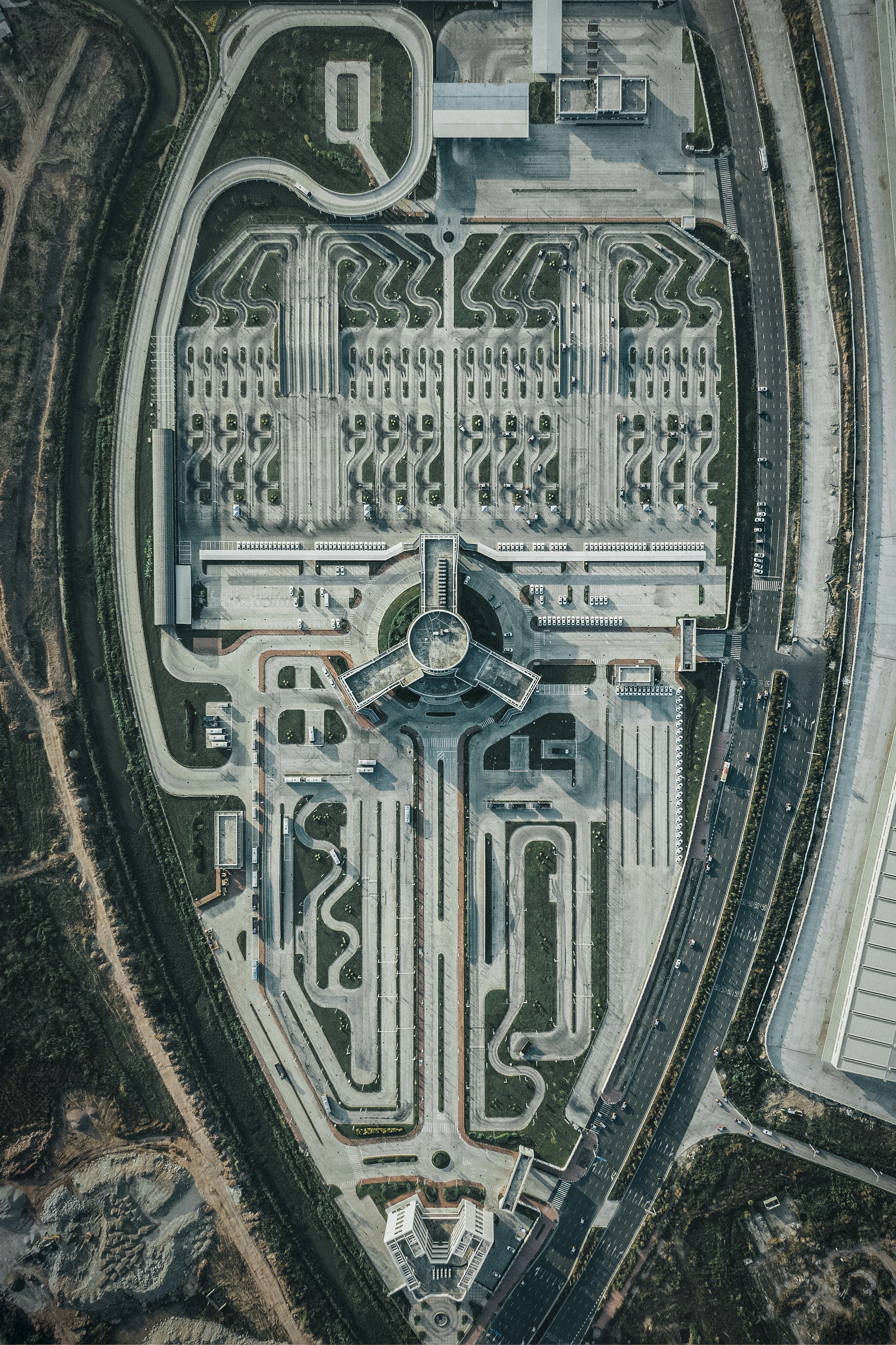 Aerial view of a complex architectural layout featuring intricate pathways and parking arrangements, showcasing modern design principles. The image highlights the harmony between functionality and aesthetics.