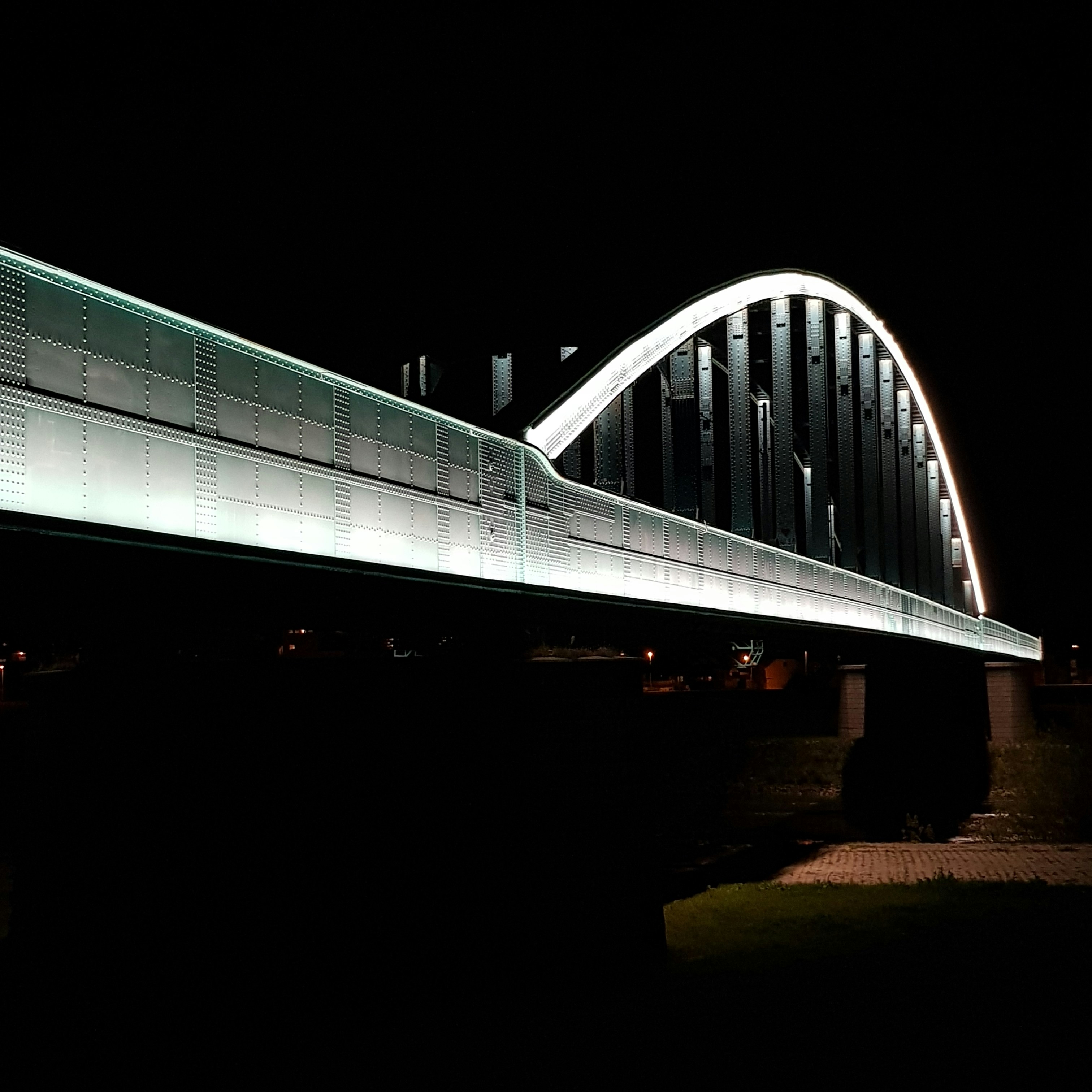 Glowing Arch Over Quiet Waters: Night Bridge