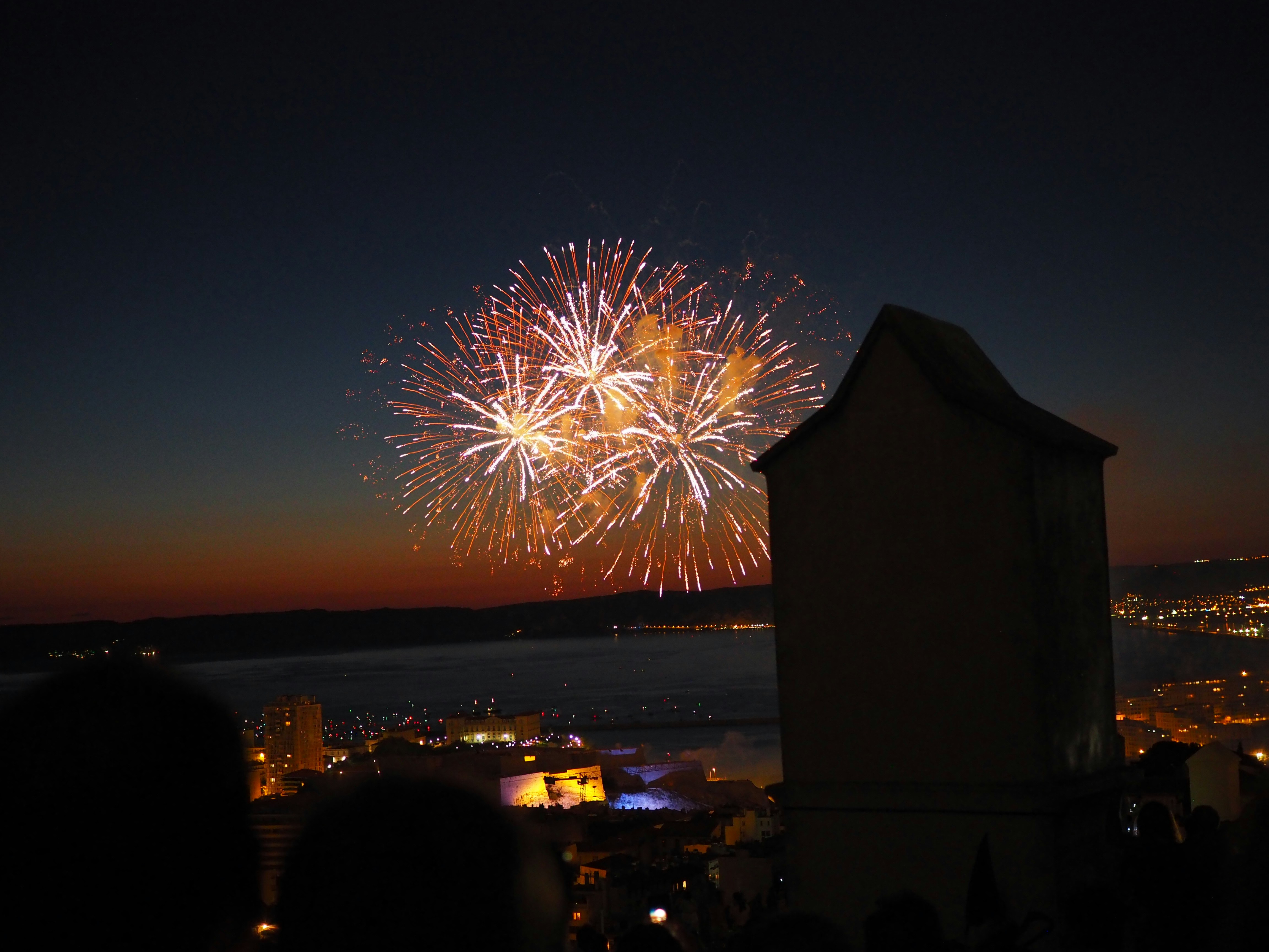 Dusk Harbor Burst: Fireworks Over a Silhouetted Waterfront City