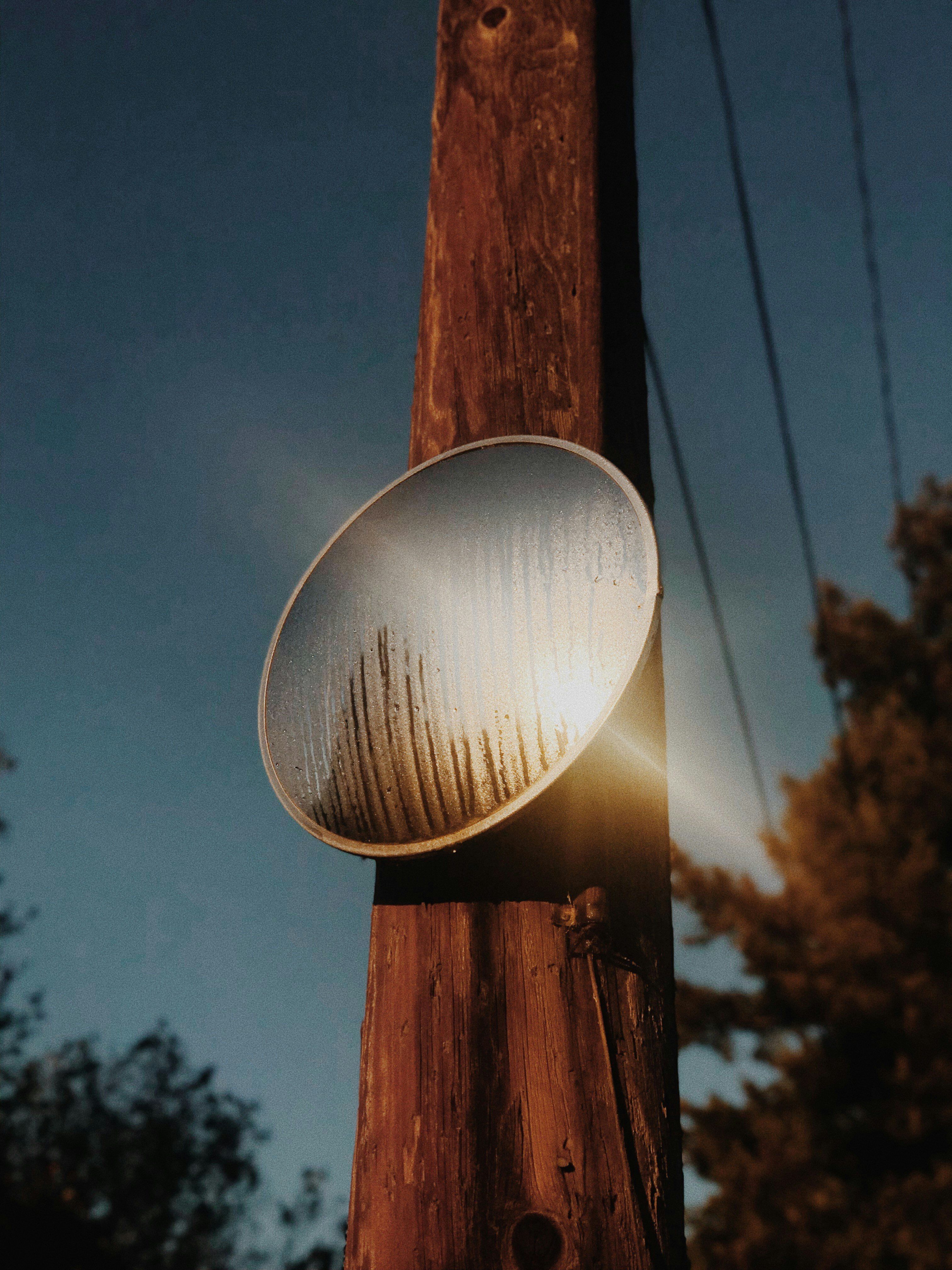 Sunlit Convex Mirror on a Weathered Utility Pole