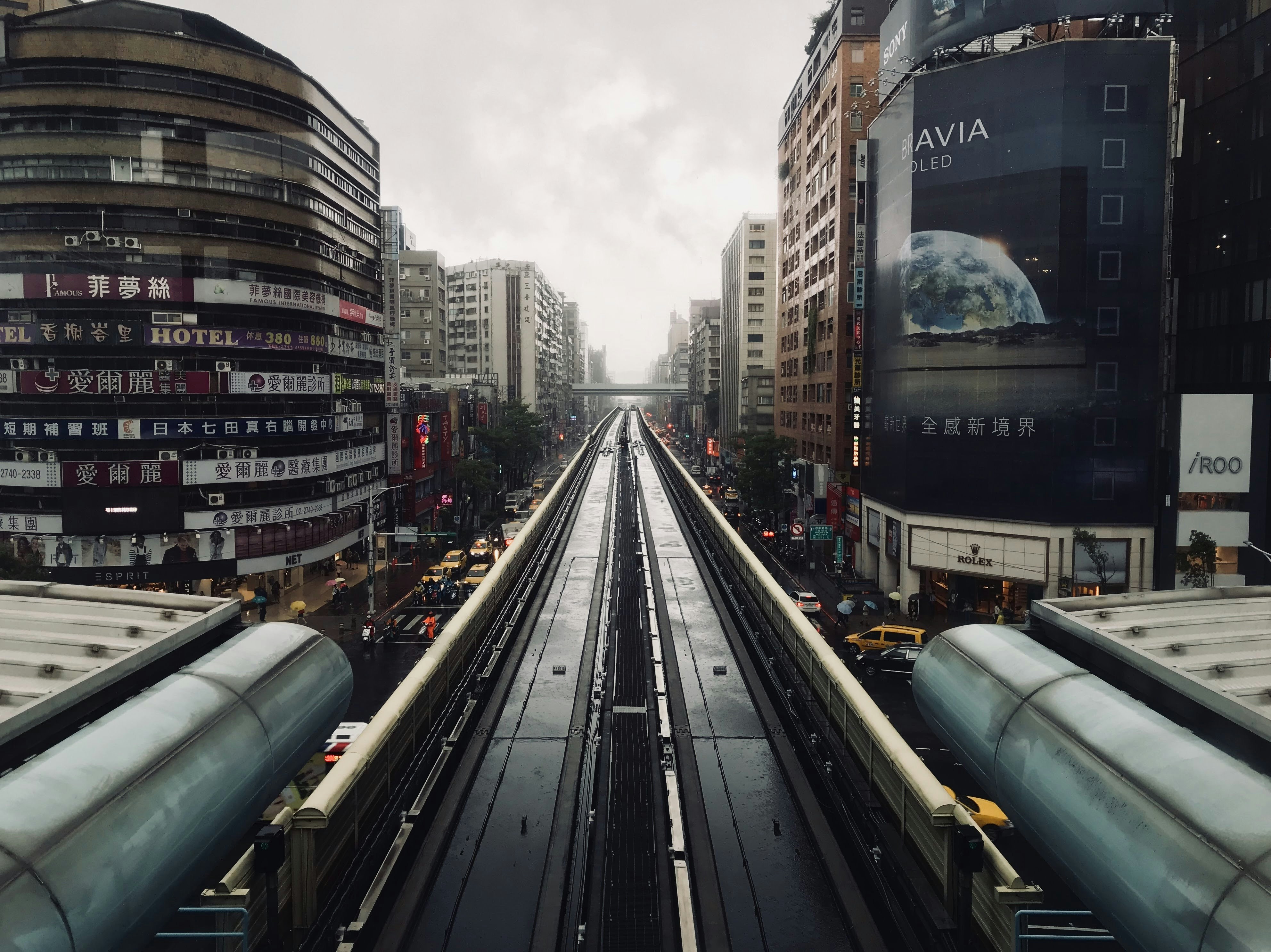 Monorail to the City: A Symmetrical Rise Through a Rainy Urban Arcade