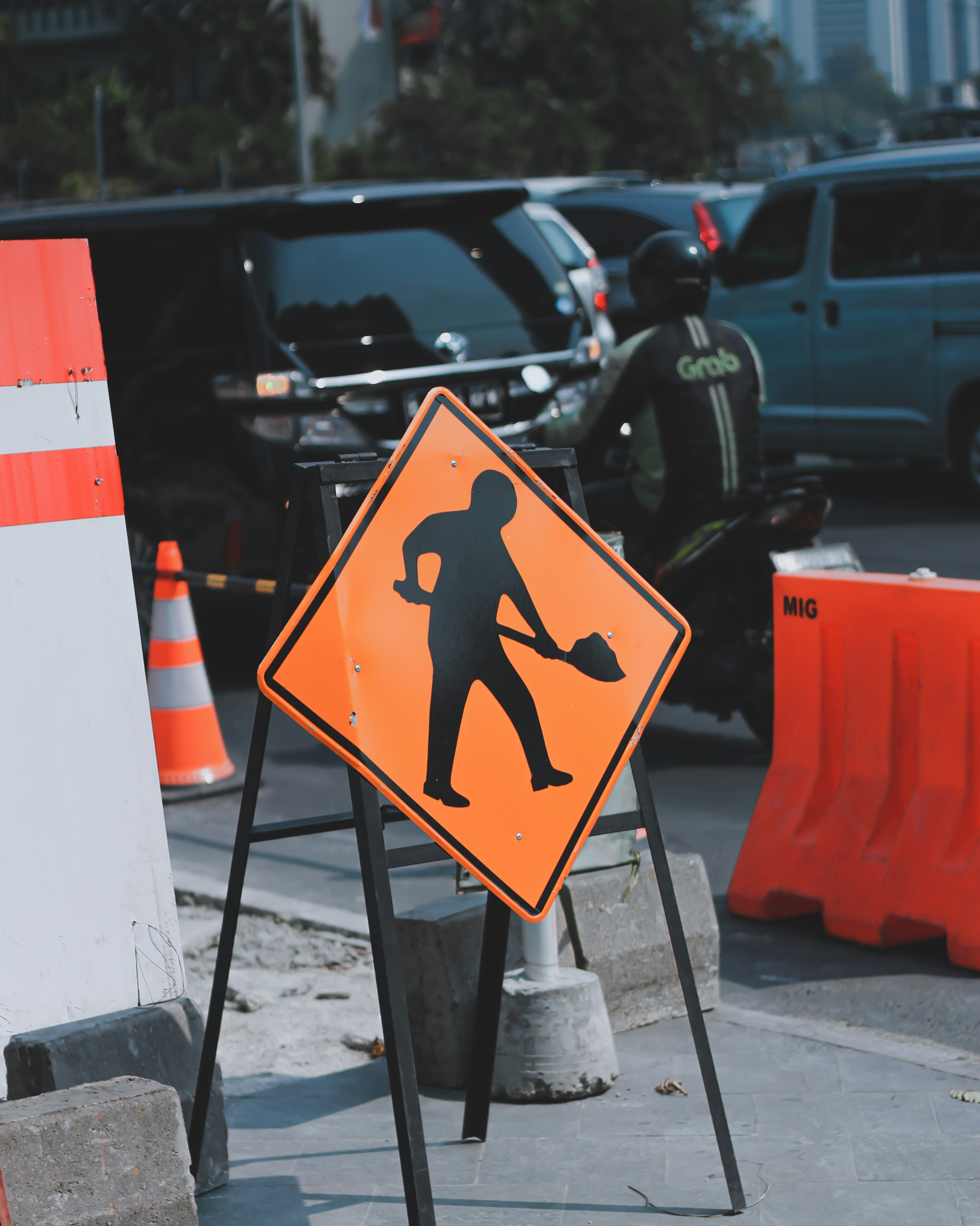 Orange Diamond Safety Sign Anchors a Busy Urban Construction Scene