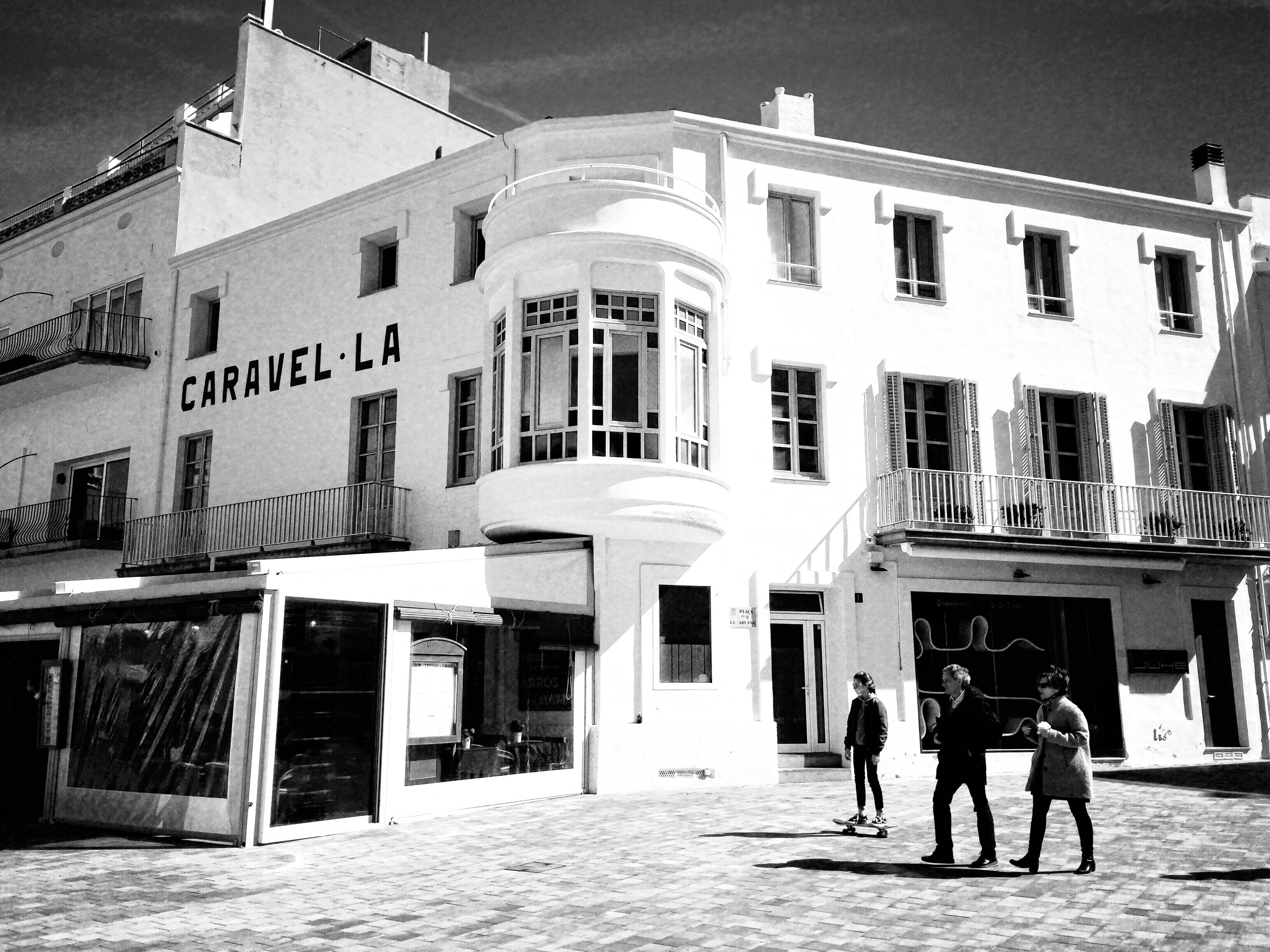 Grayscale photography of three person walking beside building photo ...