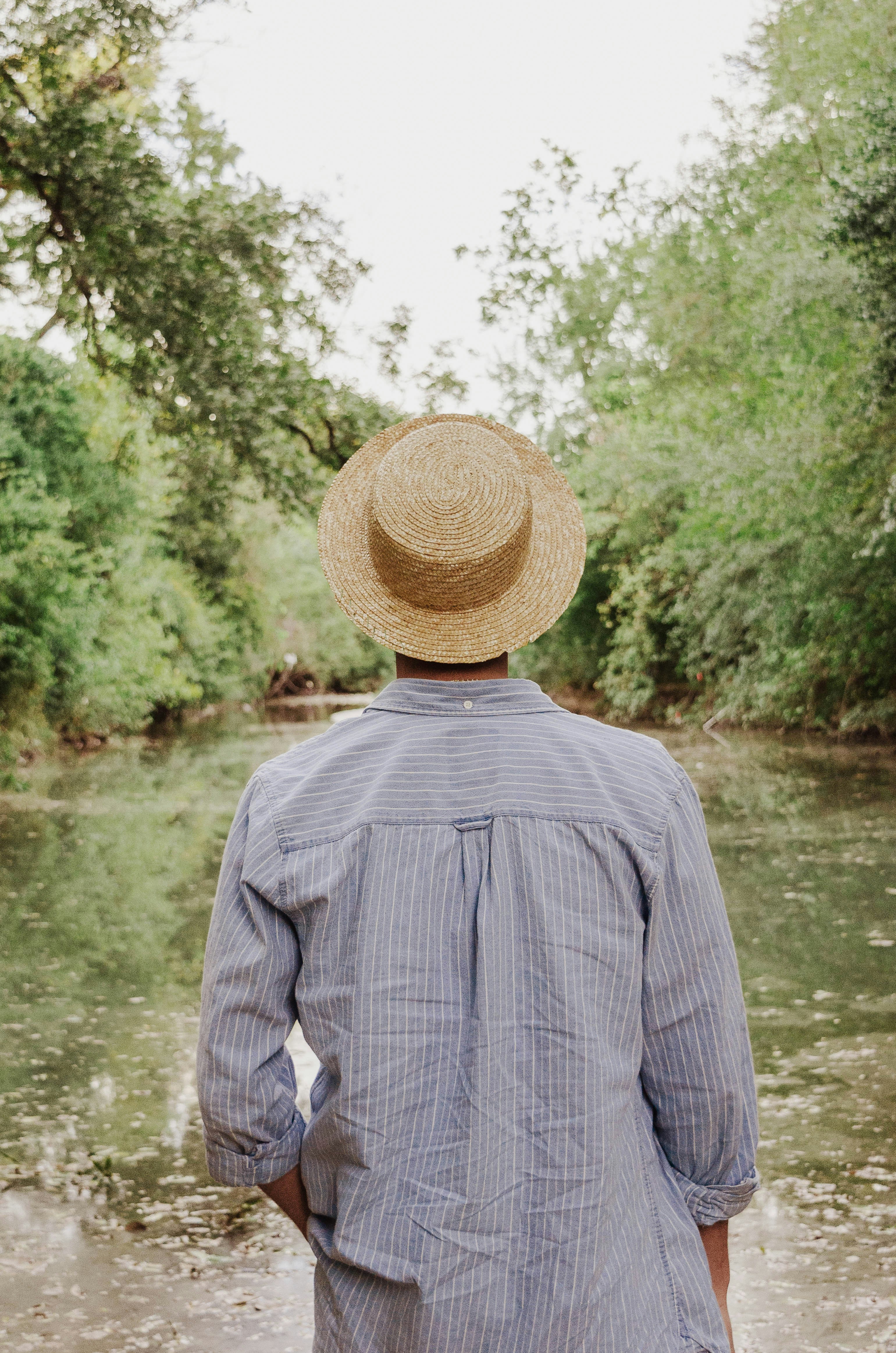 person in gray dress shirt standing near lake during daytime