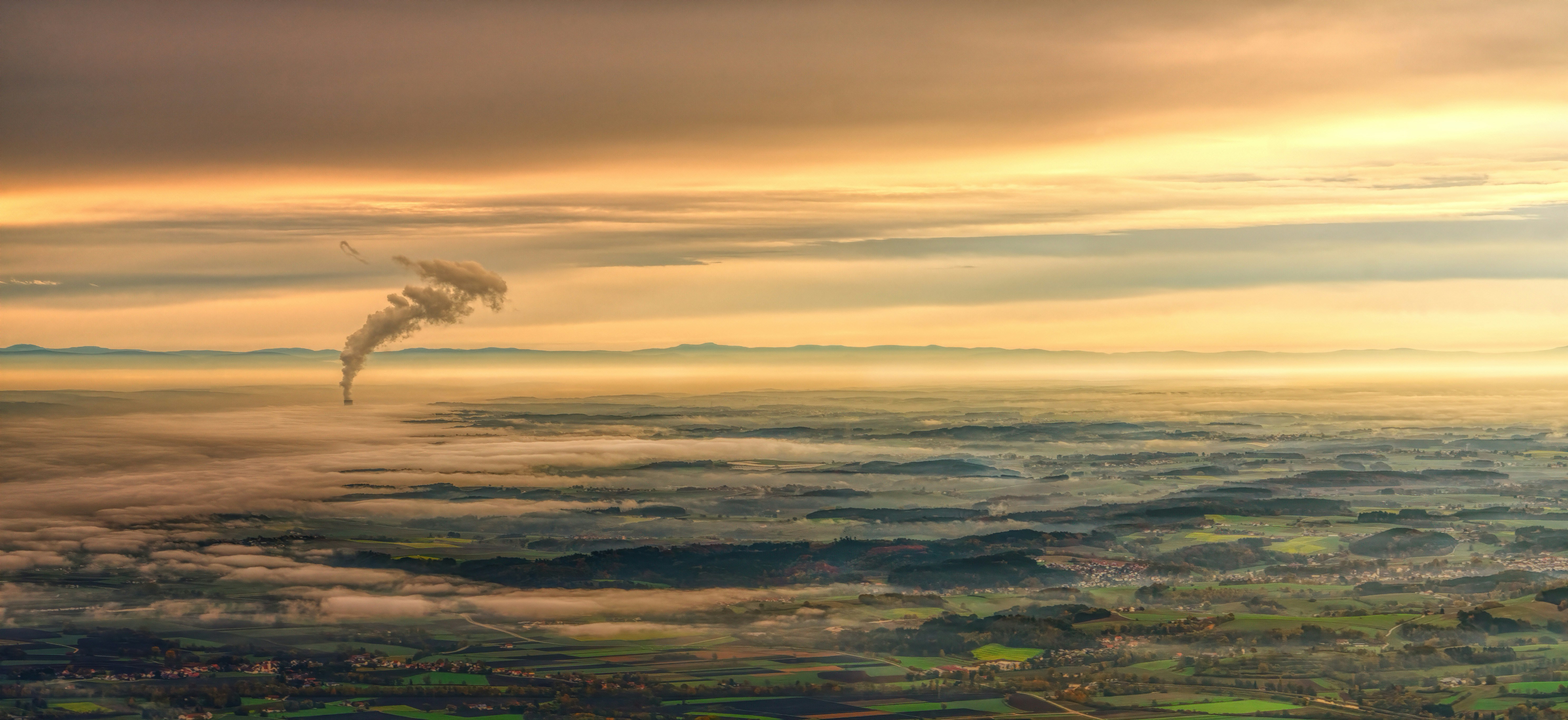 Smoke Trail over a Quiet Valley at Sunrise