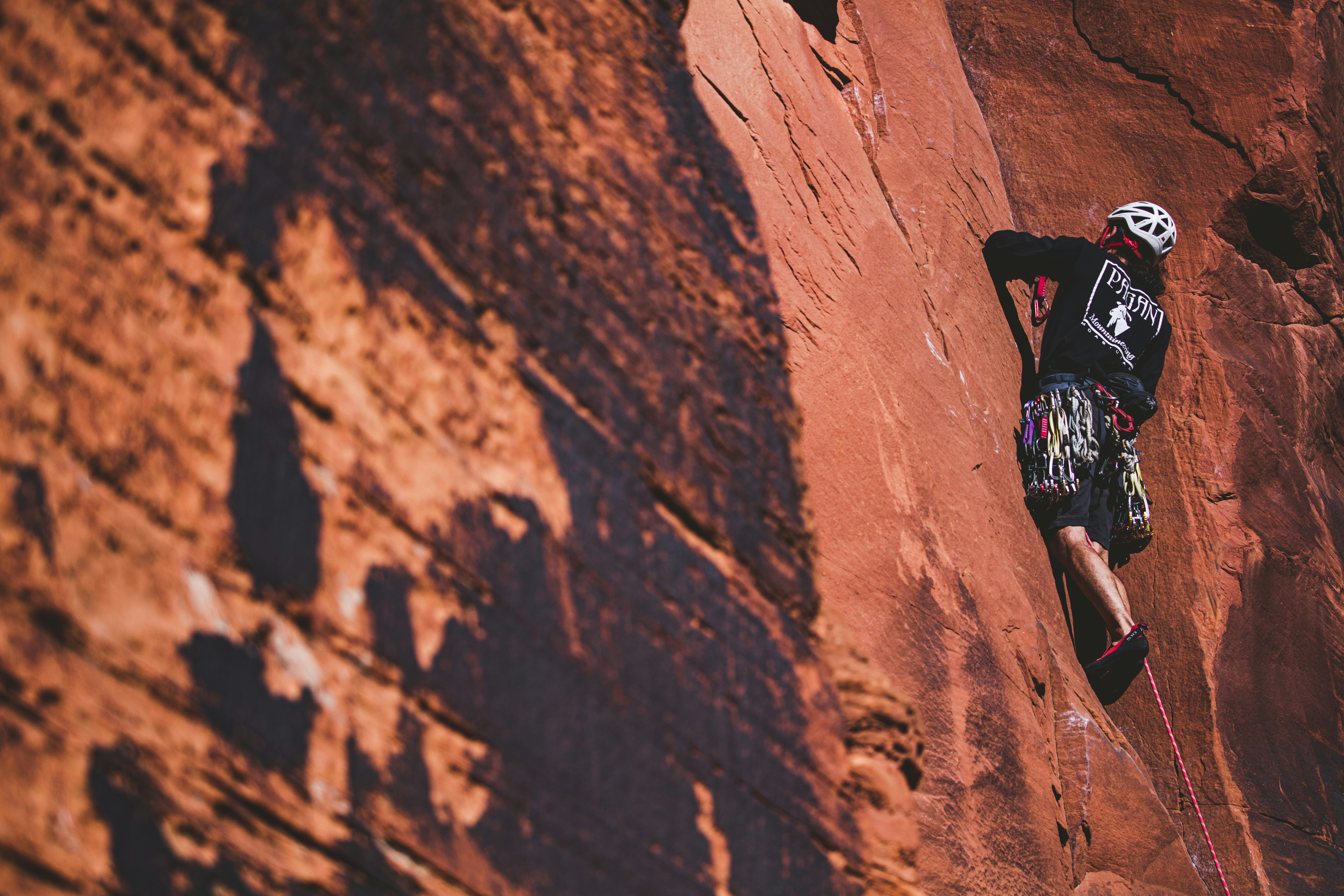 Crimson Climb: A climber's ascent on a sunlit red sandstone wall