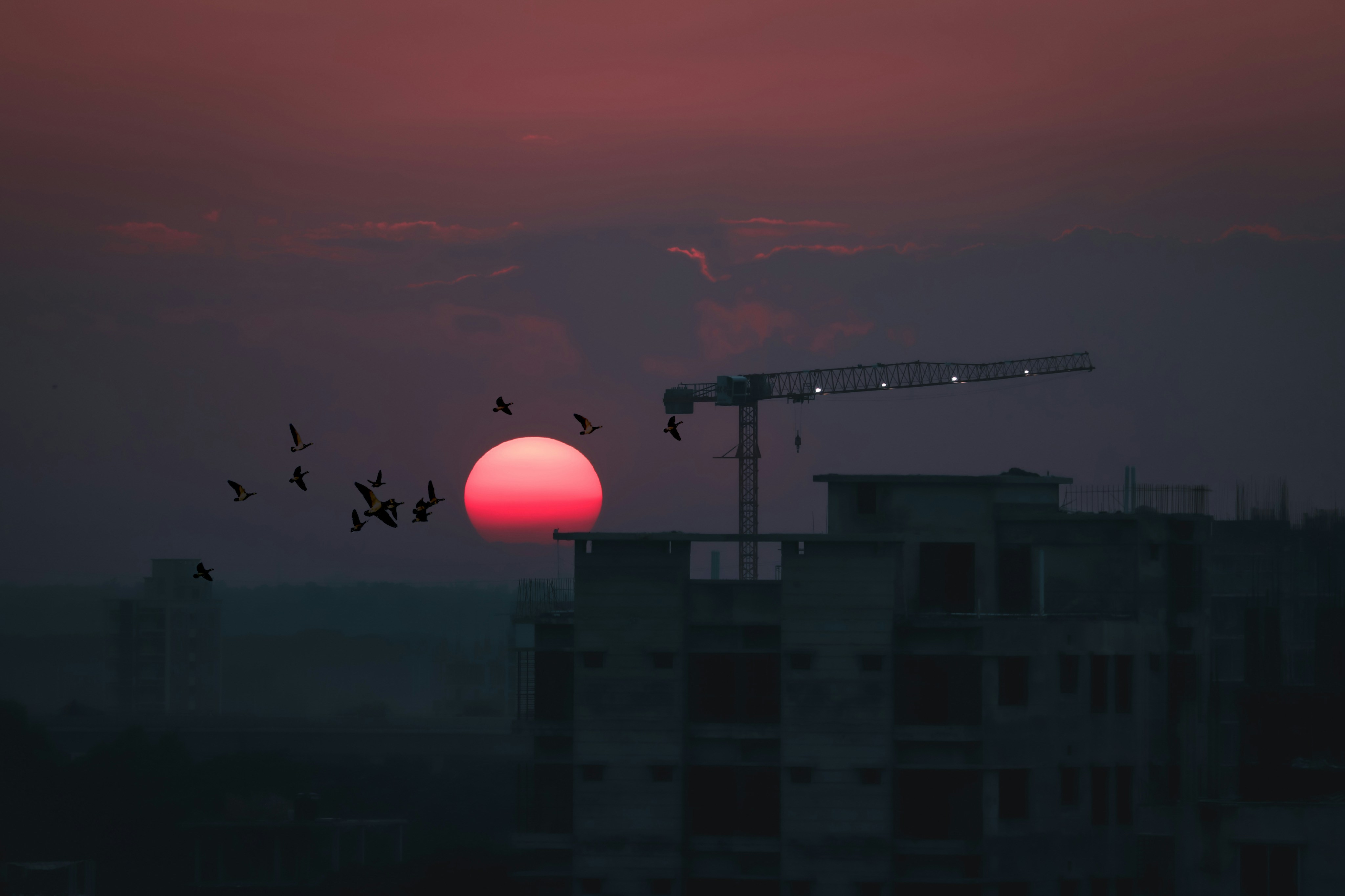 Crimson Sunset Over a Quiet Construction Horizon