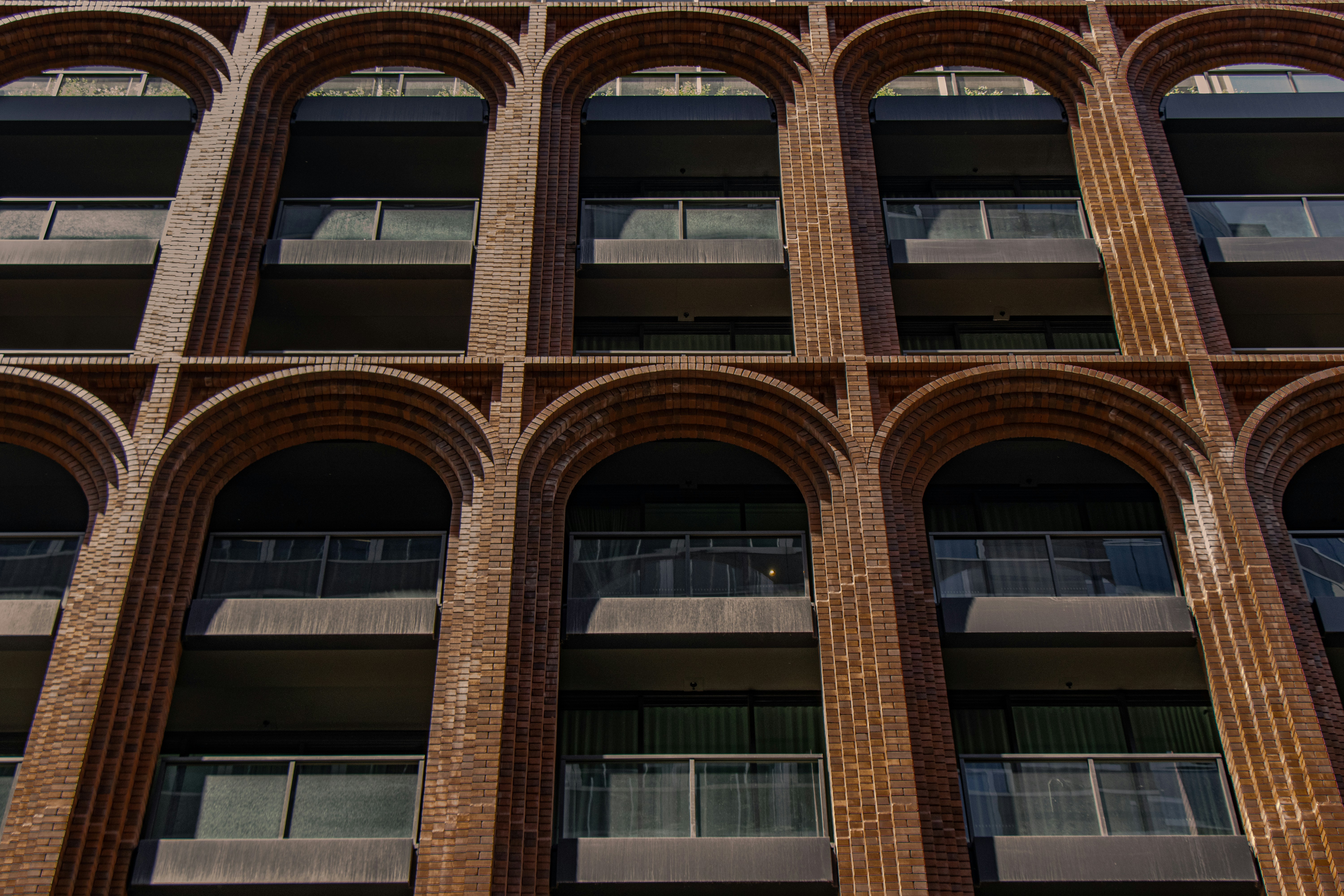 Brick arches and shadowed balconies: a grid of urban repetition