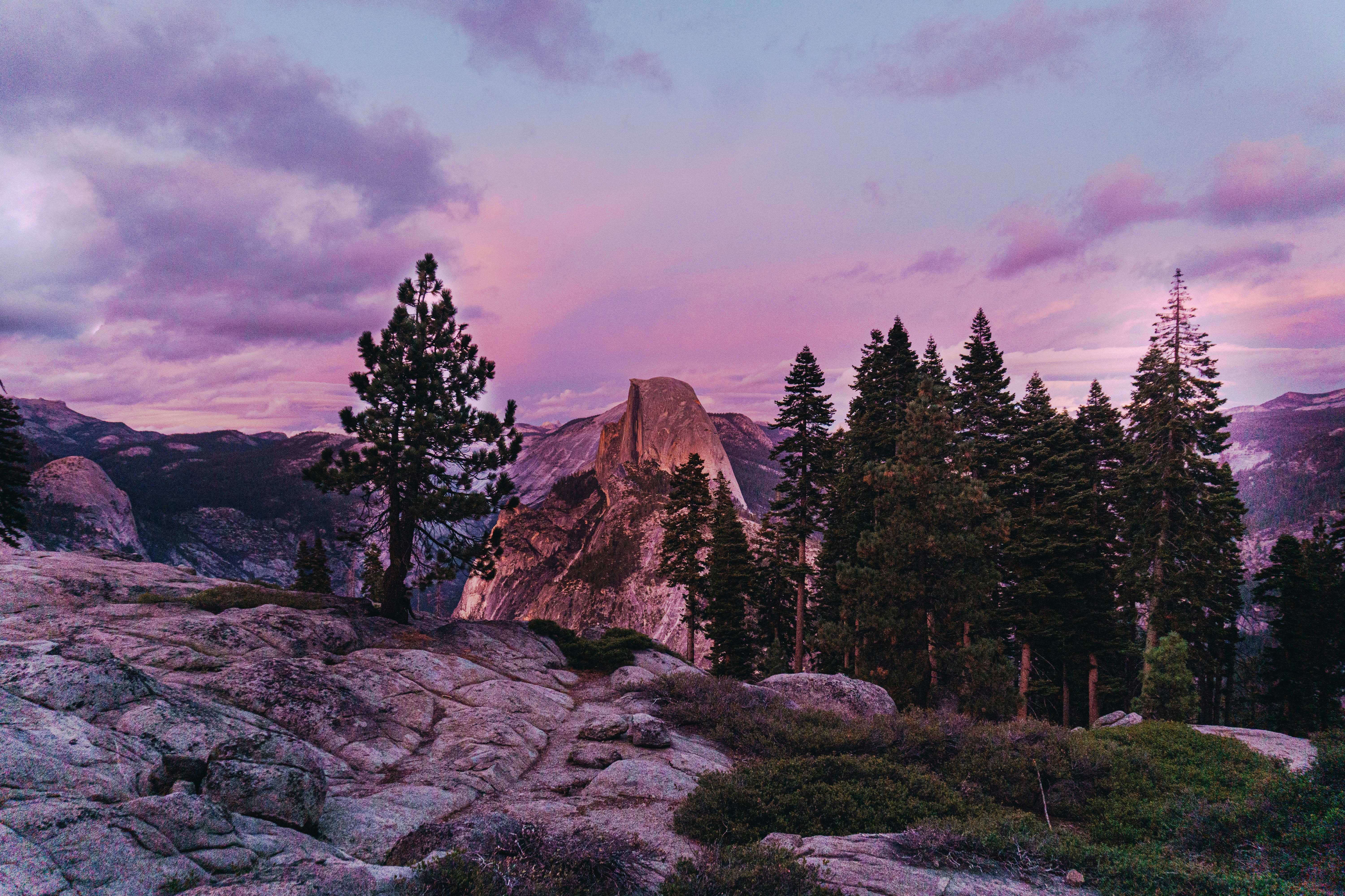 Montaña de observación de colinas rocosas bajo cielo azul y naranja ...