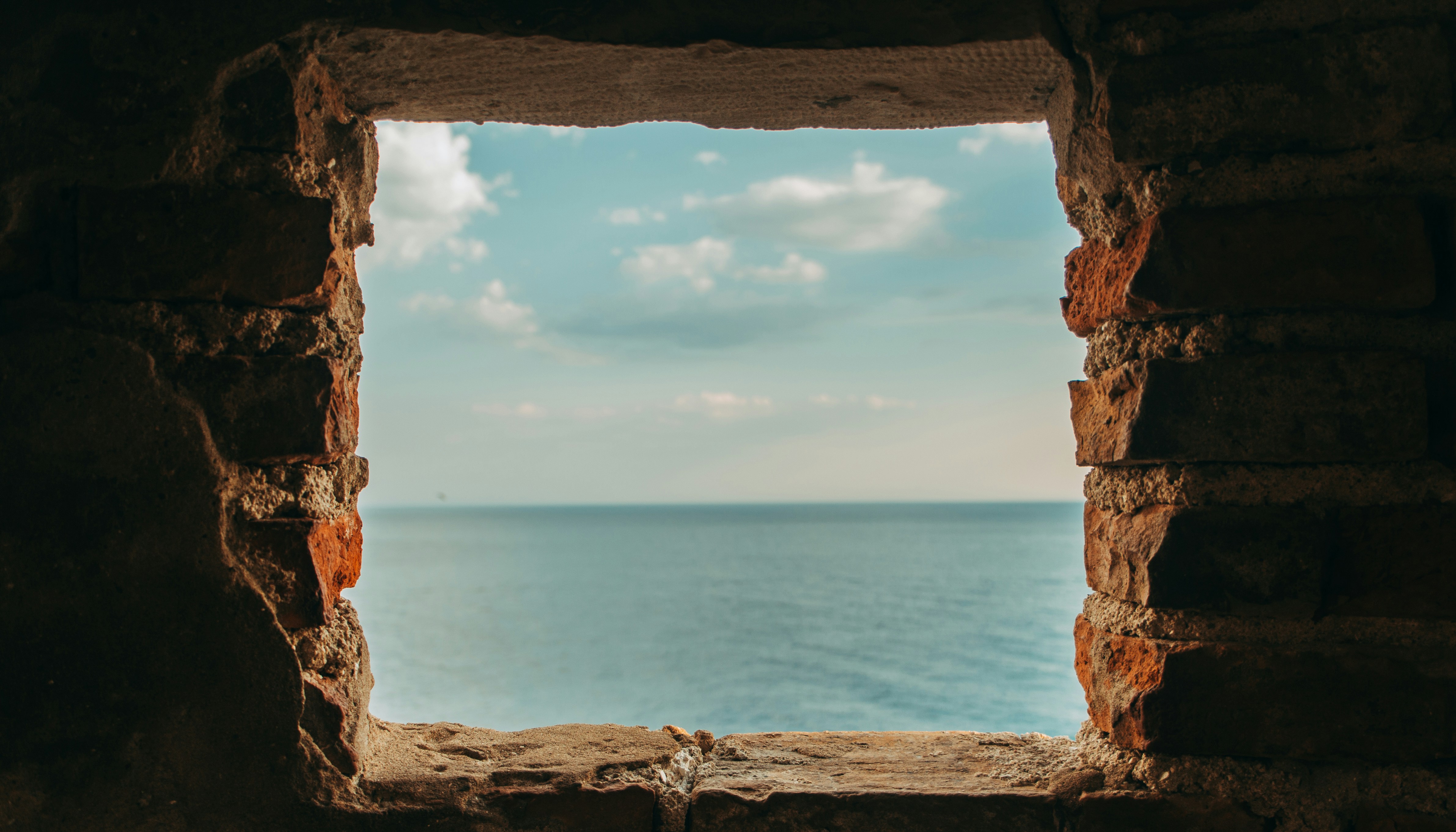 View of blue sea from a square stonewall window photo – Free Sea Image ...