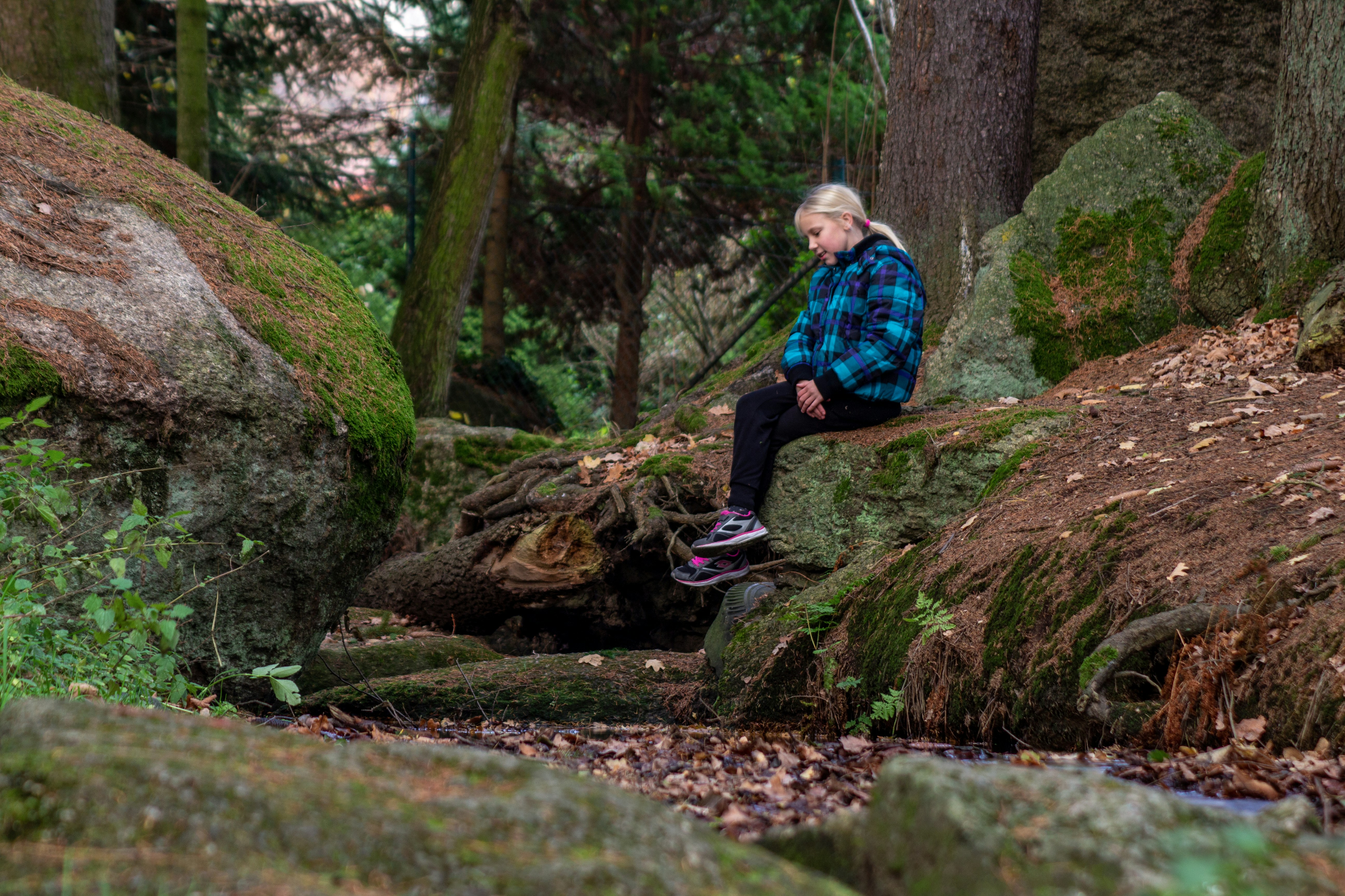 Blue Plaid Moment: Resting on Mossy Granite in a Forest Hollow