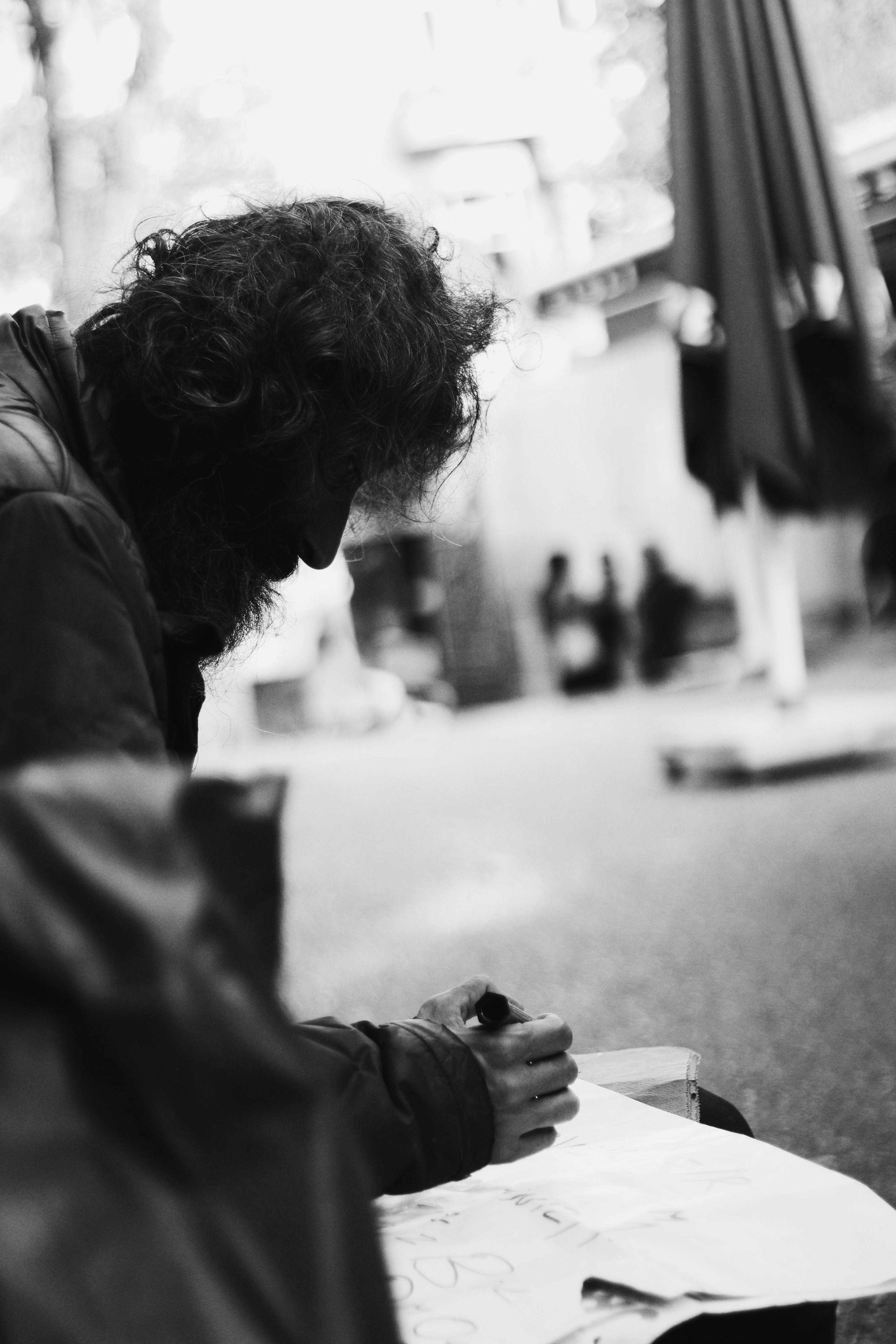 grayscale photography unknown person writing outdoors