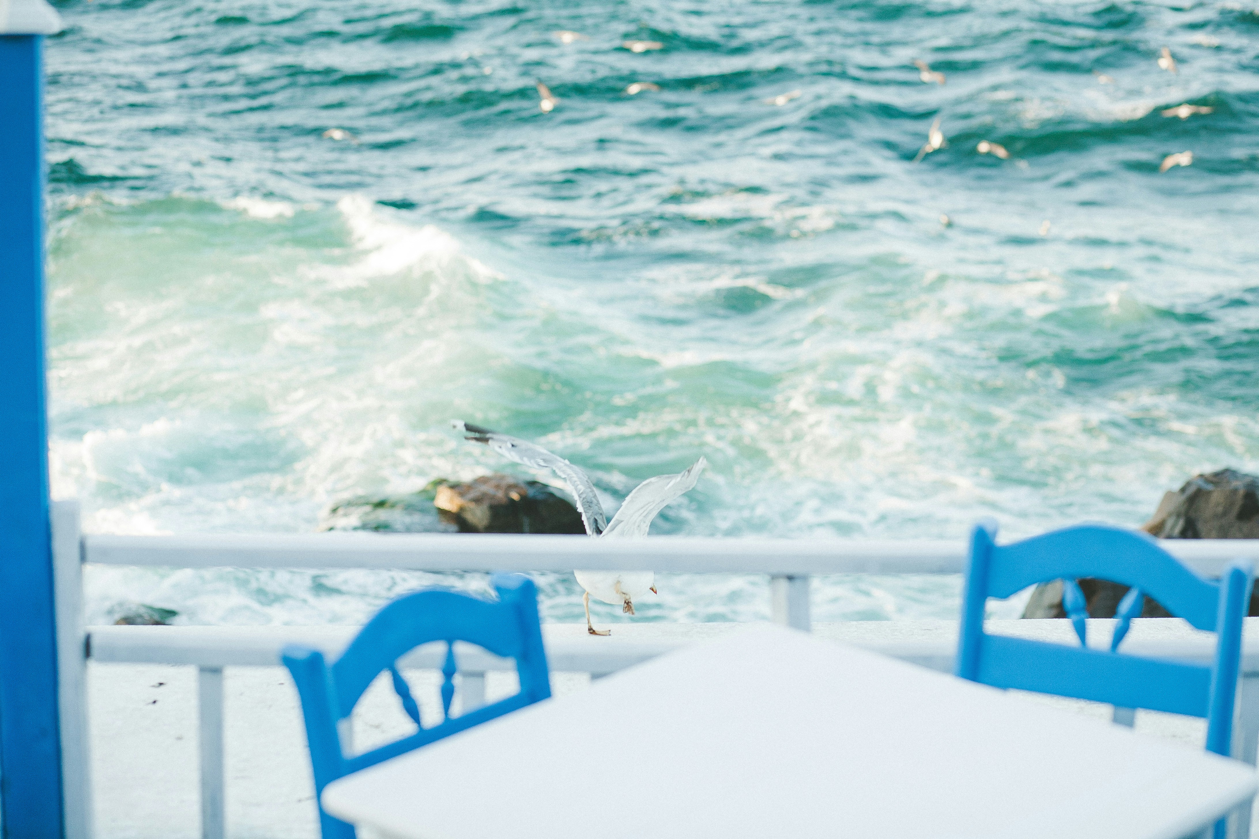 Blue Veranda at Sea: Teal Chairs Framing a Wave-kissed Deck