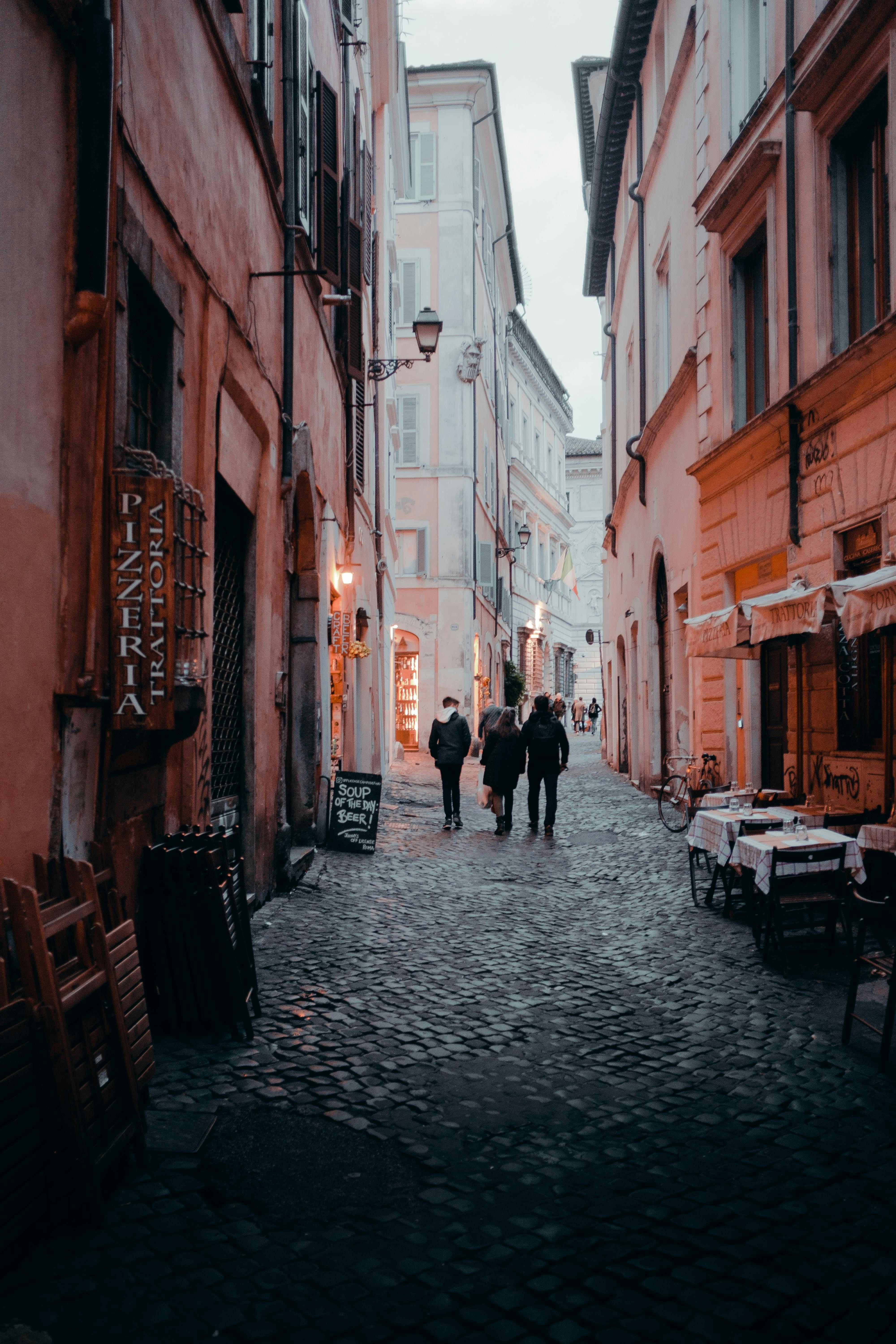 Three persons walking between building during daytime photo – Free Roma ...