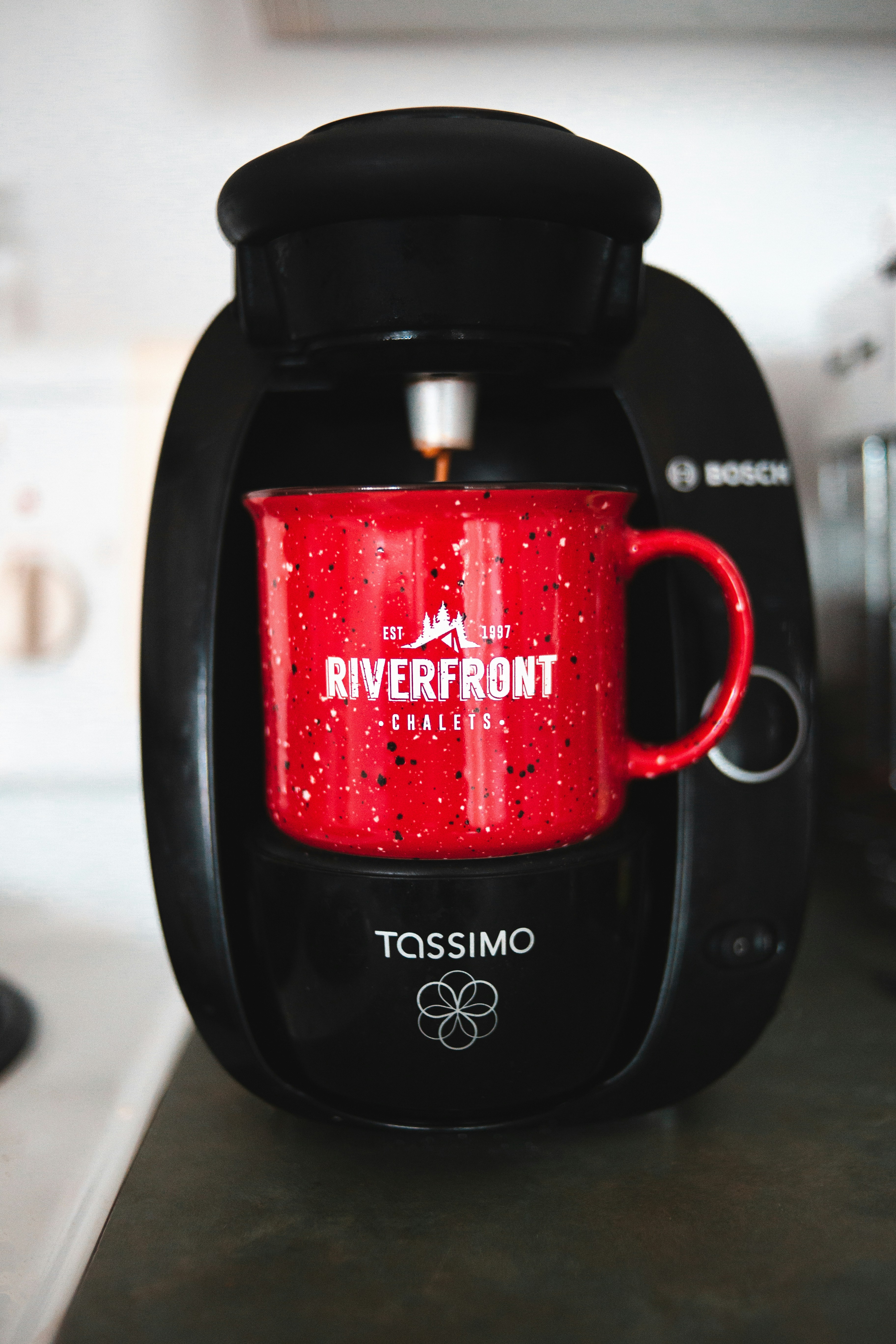 Cafetière Tassimo noire et mug rouge sur surface noire photo – Photo ...
