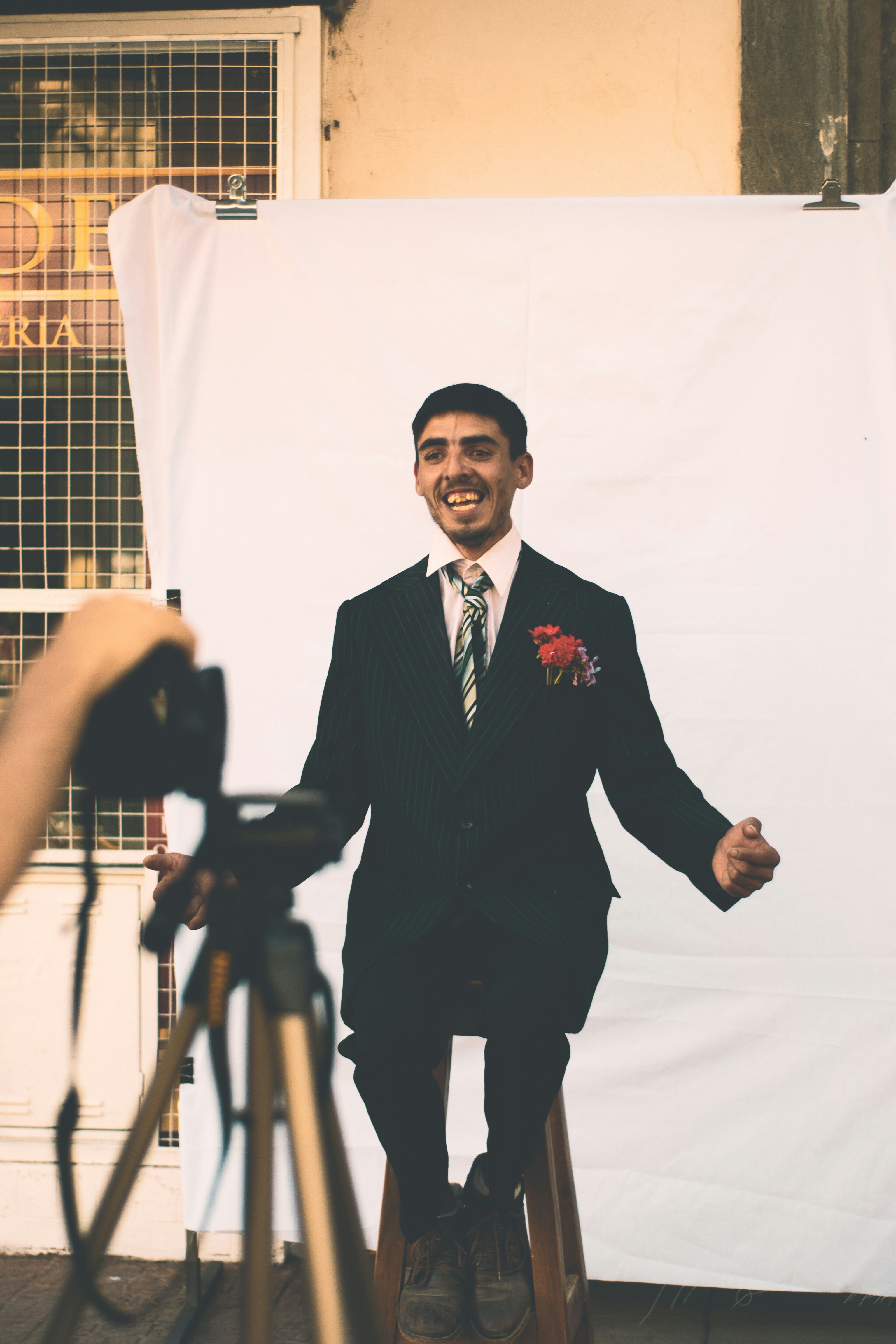 Joyful Groom in Pinstripes Before a Clean Studio Backdrop