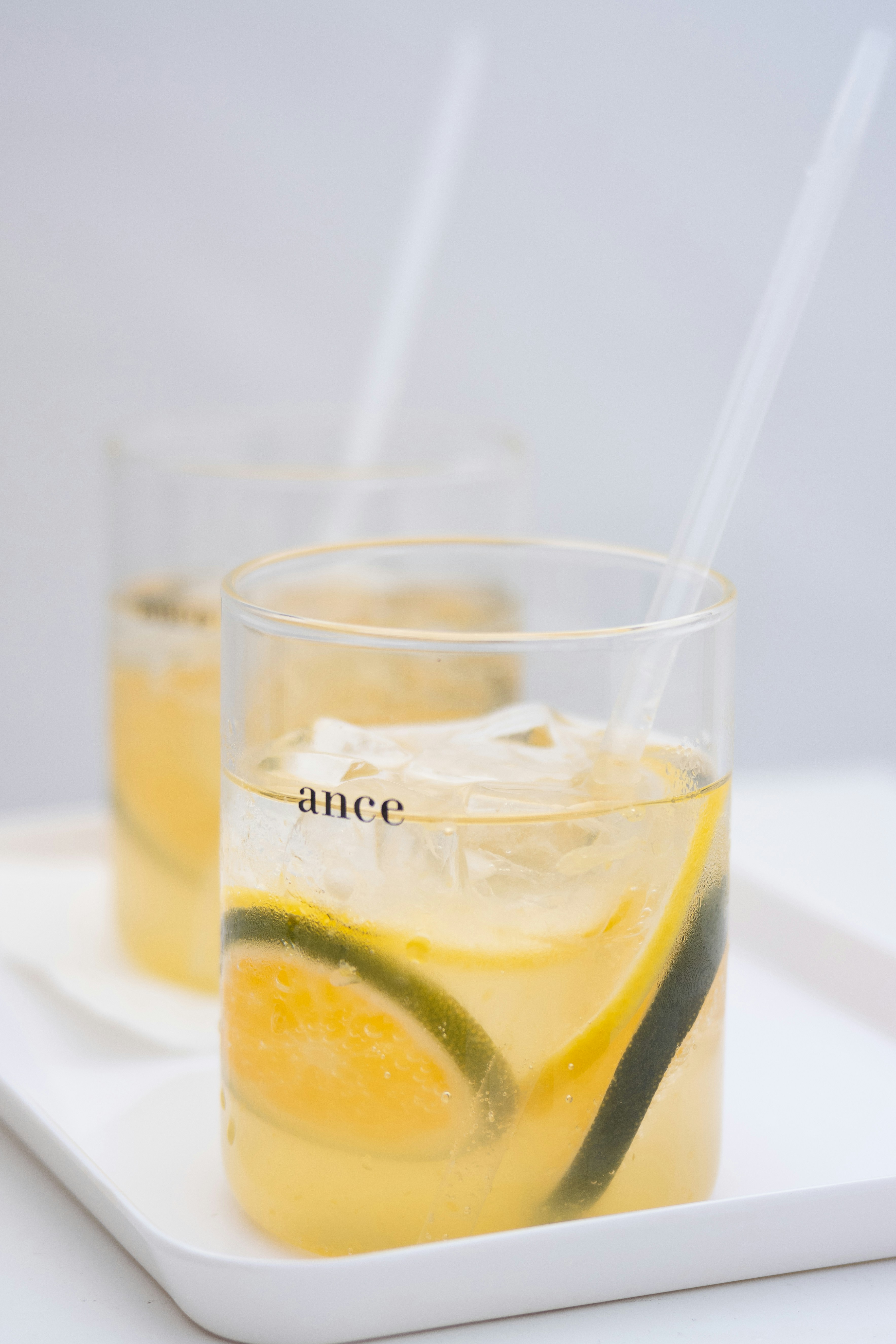 two glasses of lemonade on a white tray
